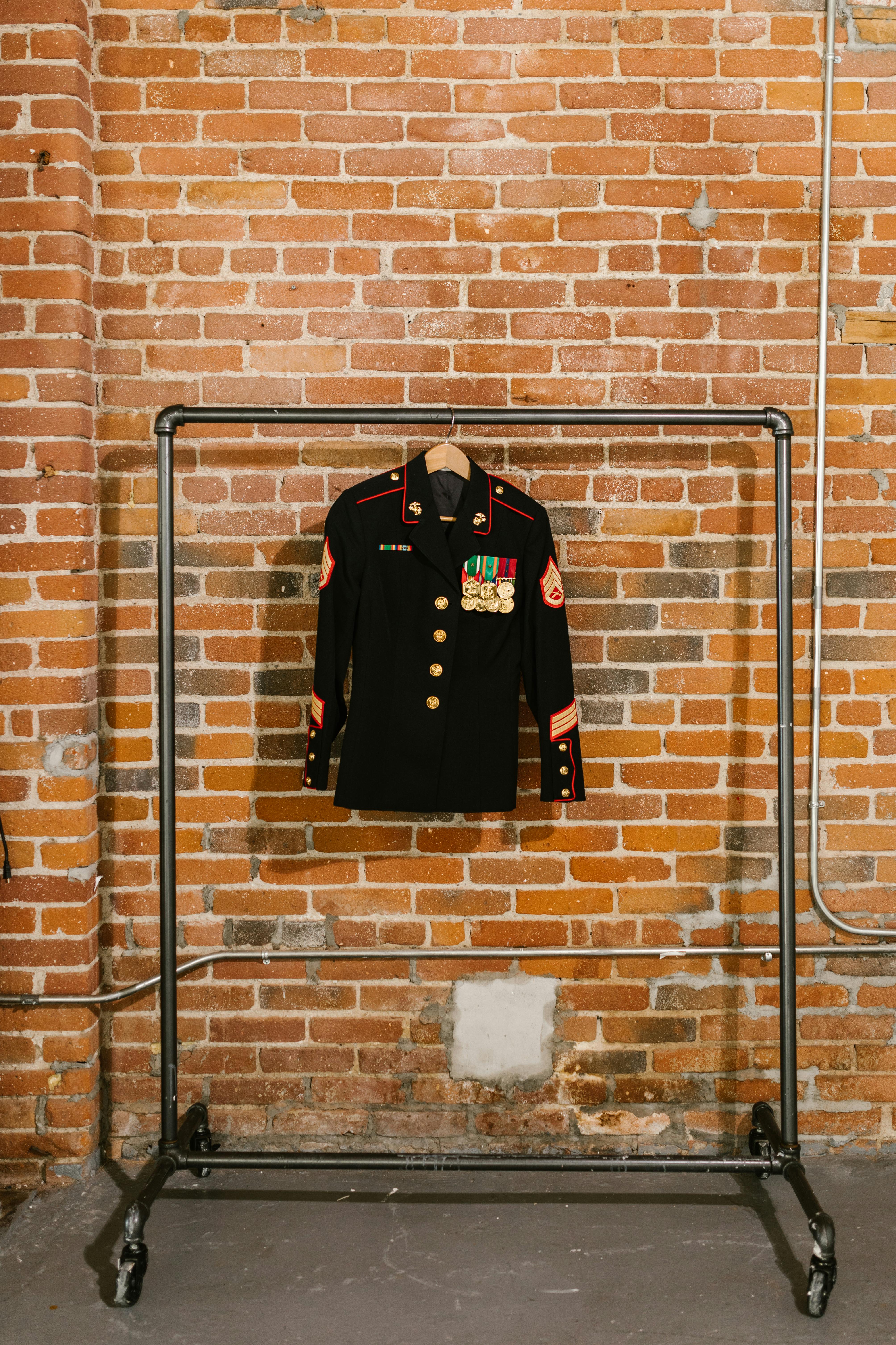 Photo of Military Uniforms Hanging on Clothing Rack · Free Stock Photo