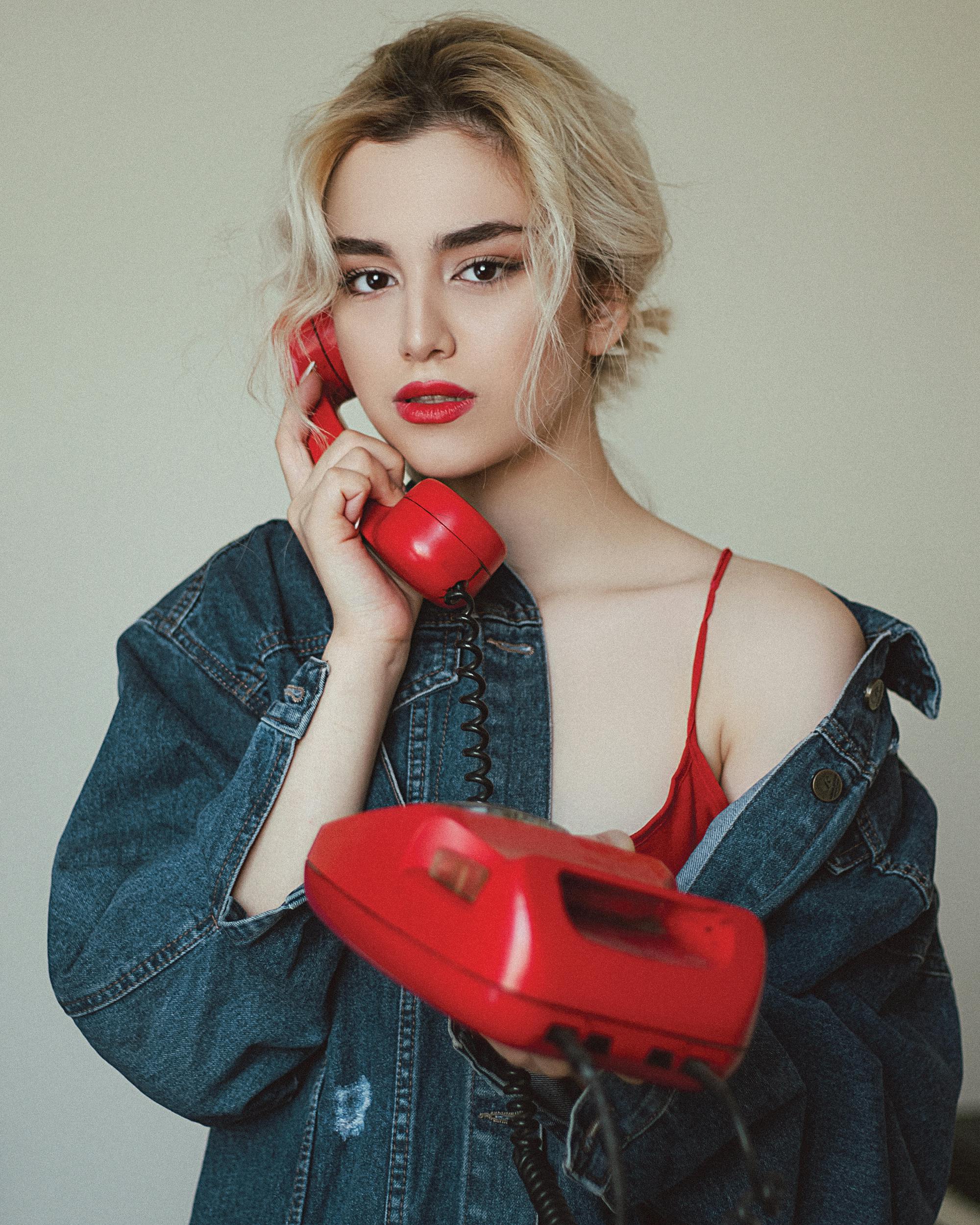 Photo of a Woman Using a Red Telephone · Free Stock Photo