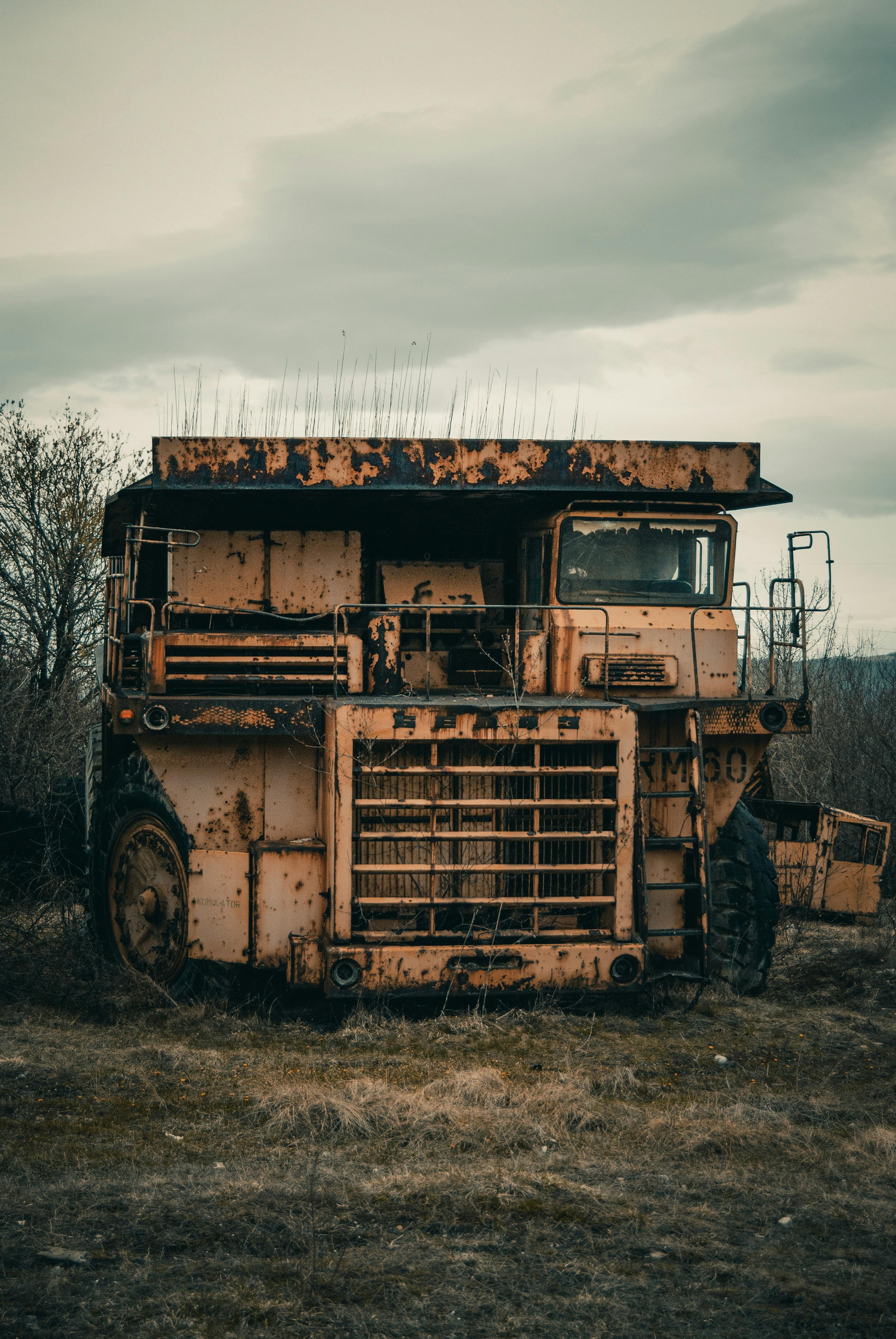 Orange and Black Tractor Next to Piles of Rocks · Free Stock Photo