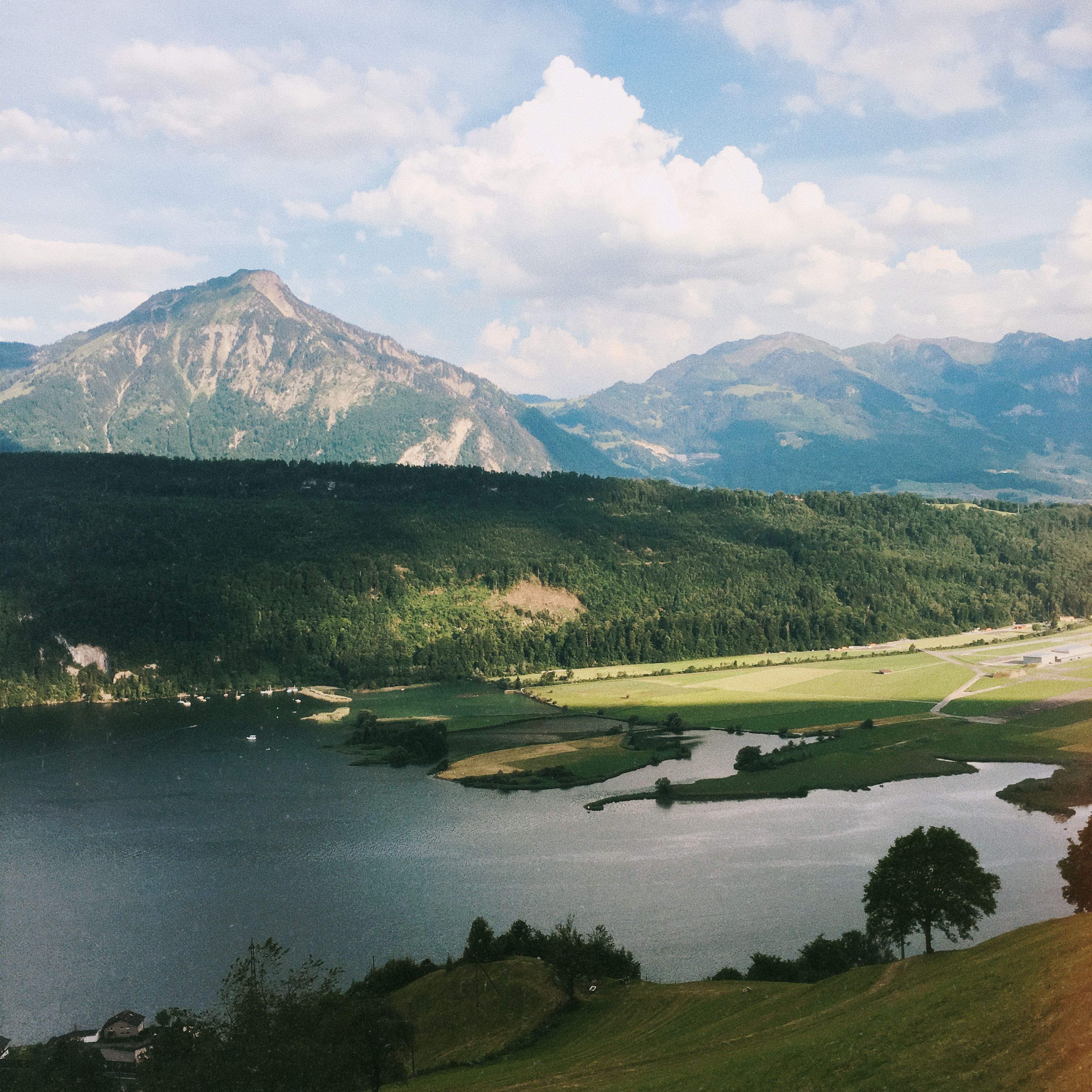 Green Grass Field Near Lake and Mountain · Free Stock Photo