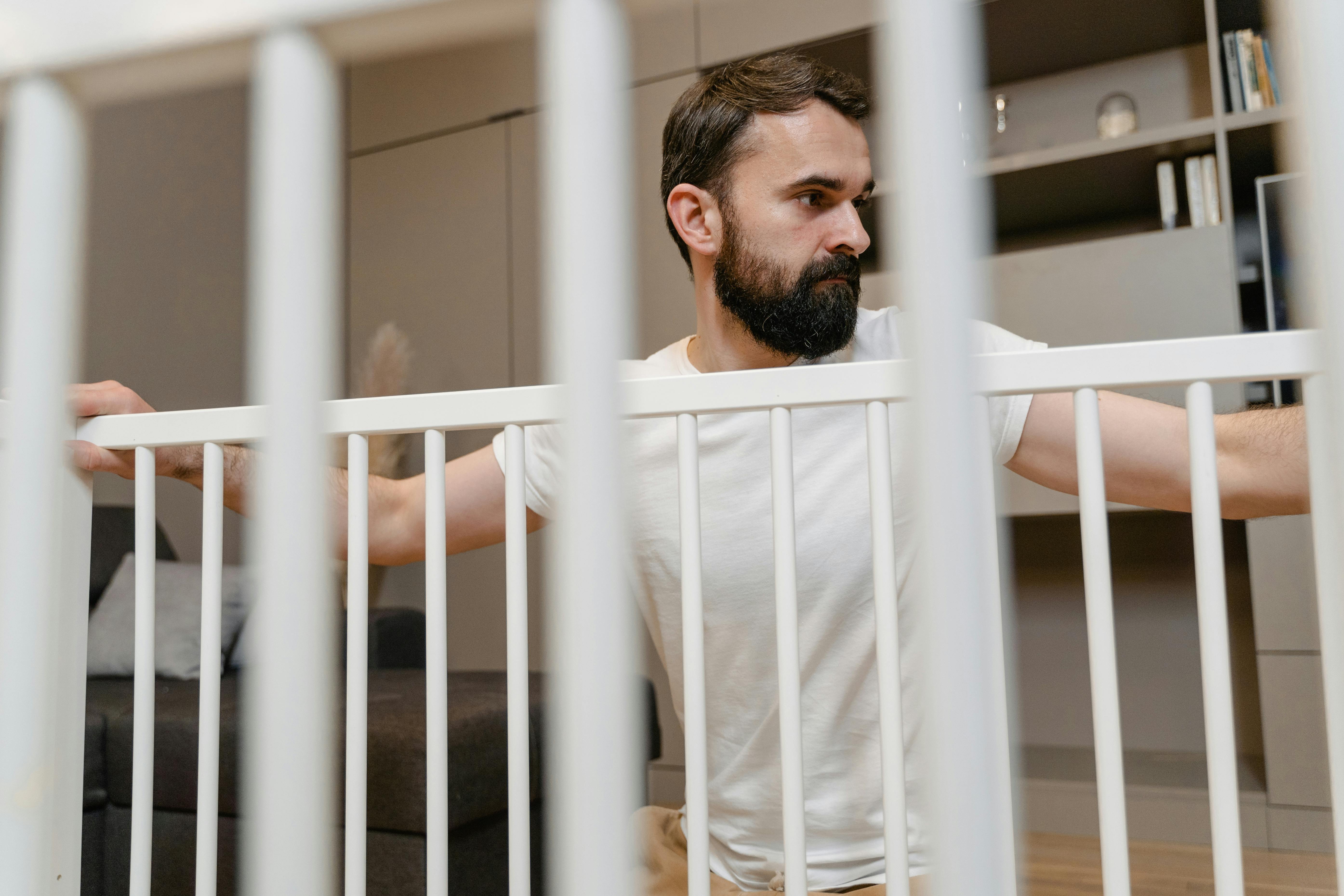A Man with a Beard Building a Crib · Free Stock Photo