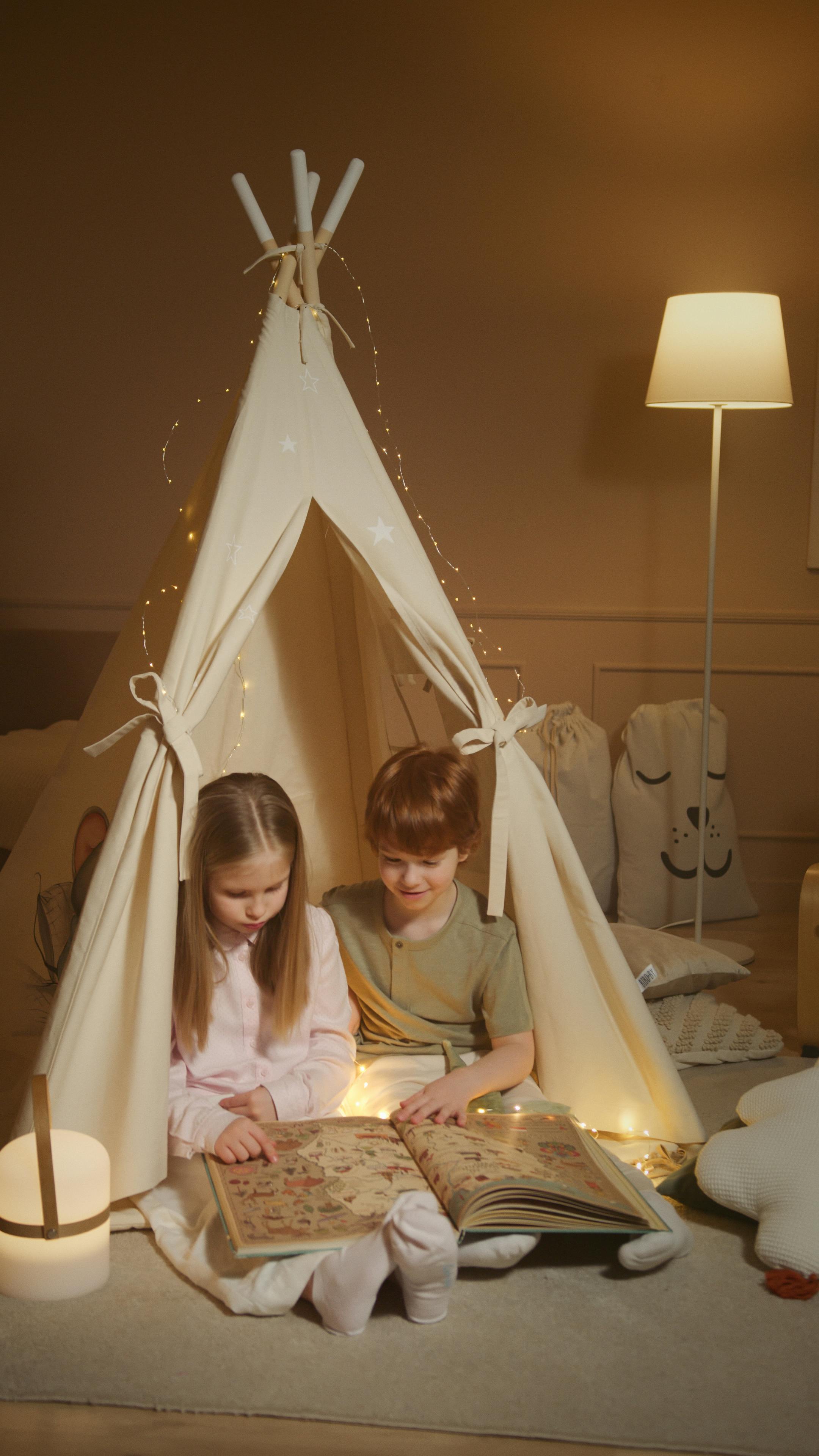 Children Reading a Book while inside an Indoor Tent · Free Stock Photo