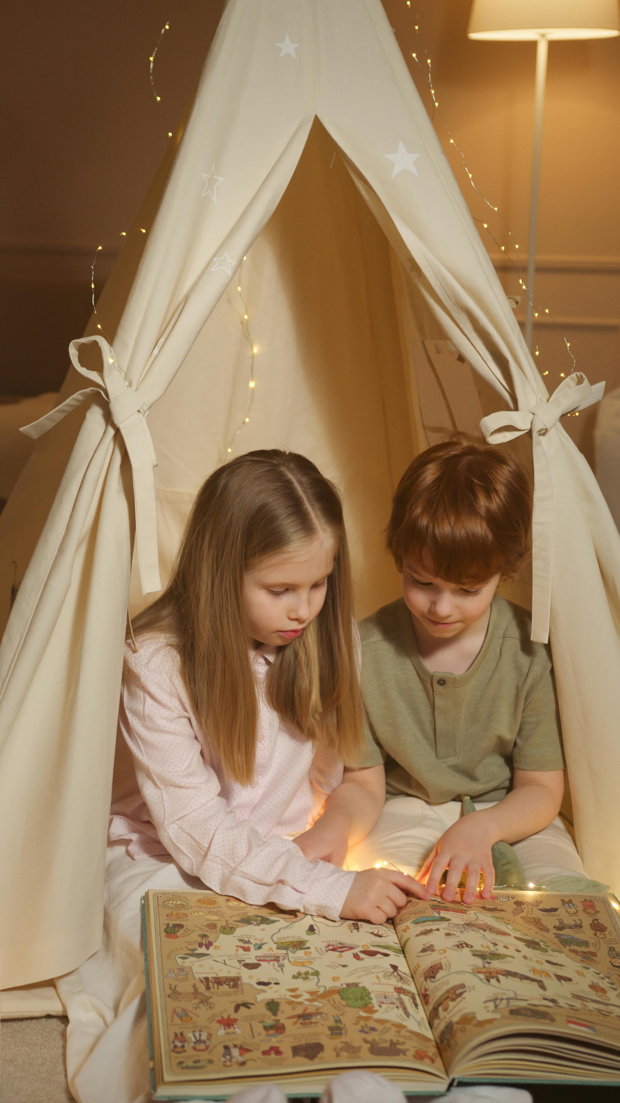 Children Reading a Book while inside an Indoor Tent · Free Stock Photo