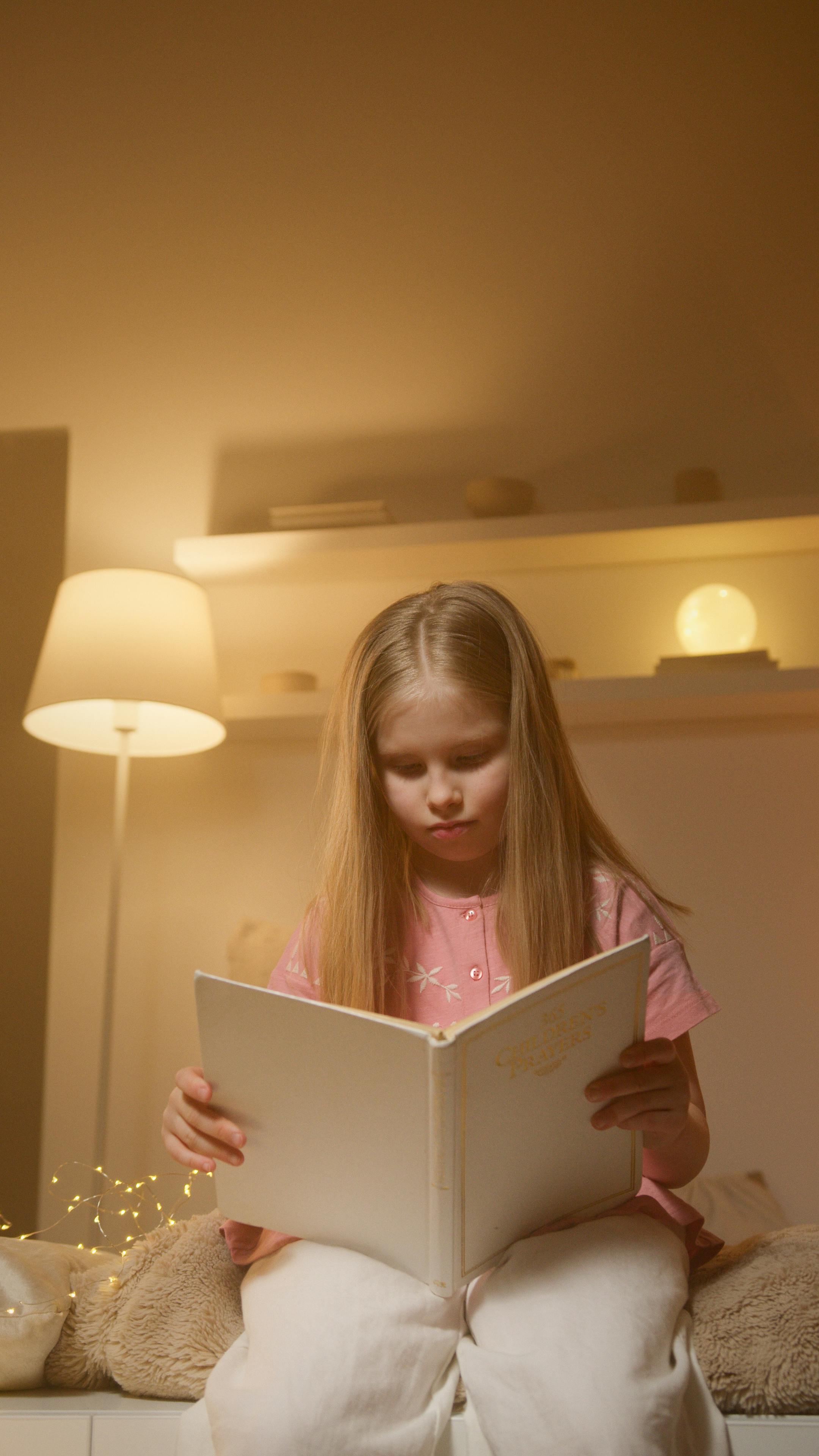 A Girl in a Pink Shirt Reading a Book · Free Stock Photo