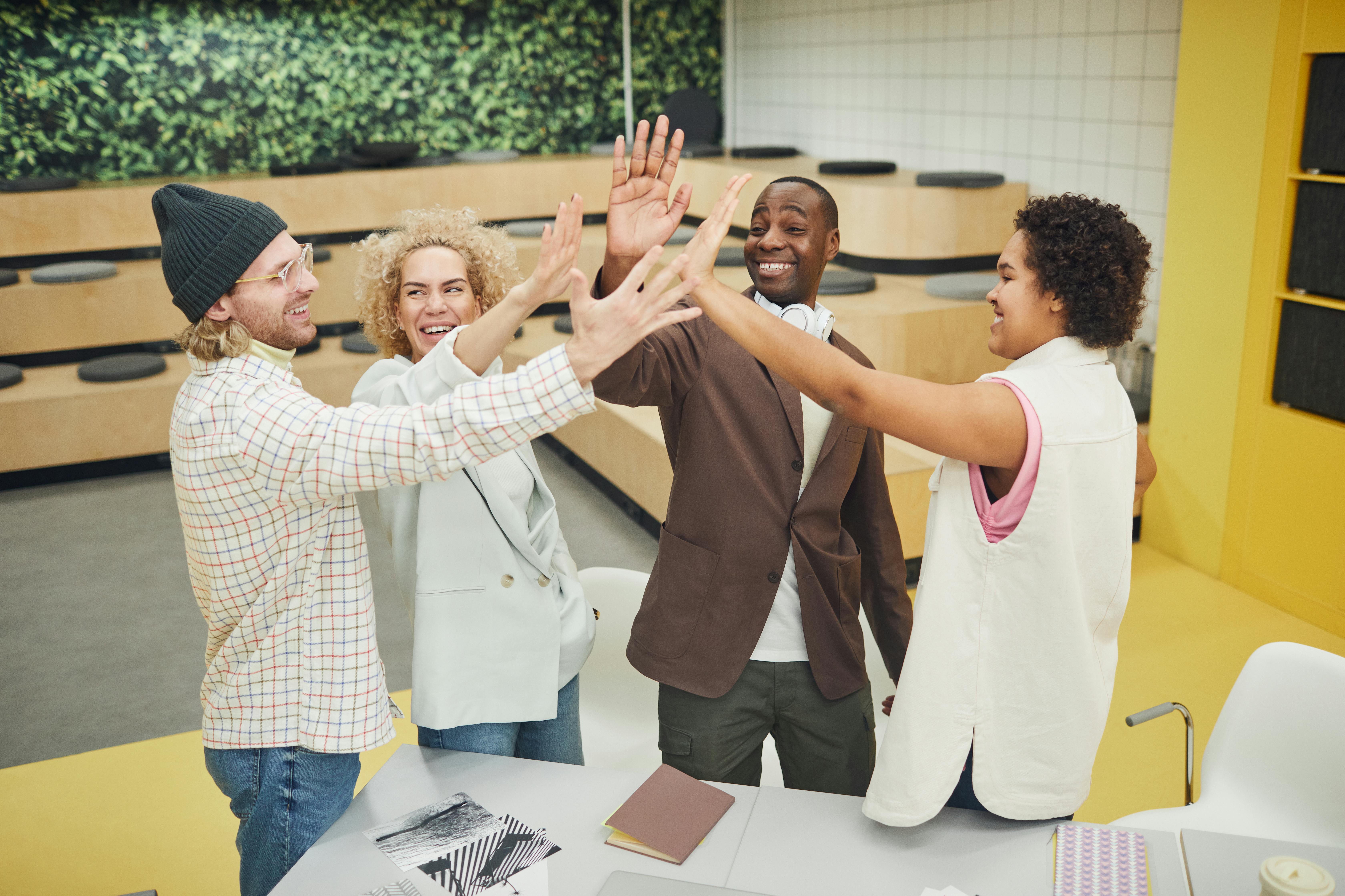 A Group of People Beside a Table doing High Five · Free Stock Photo