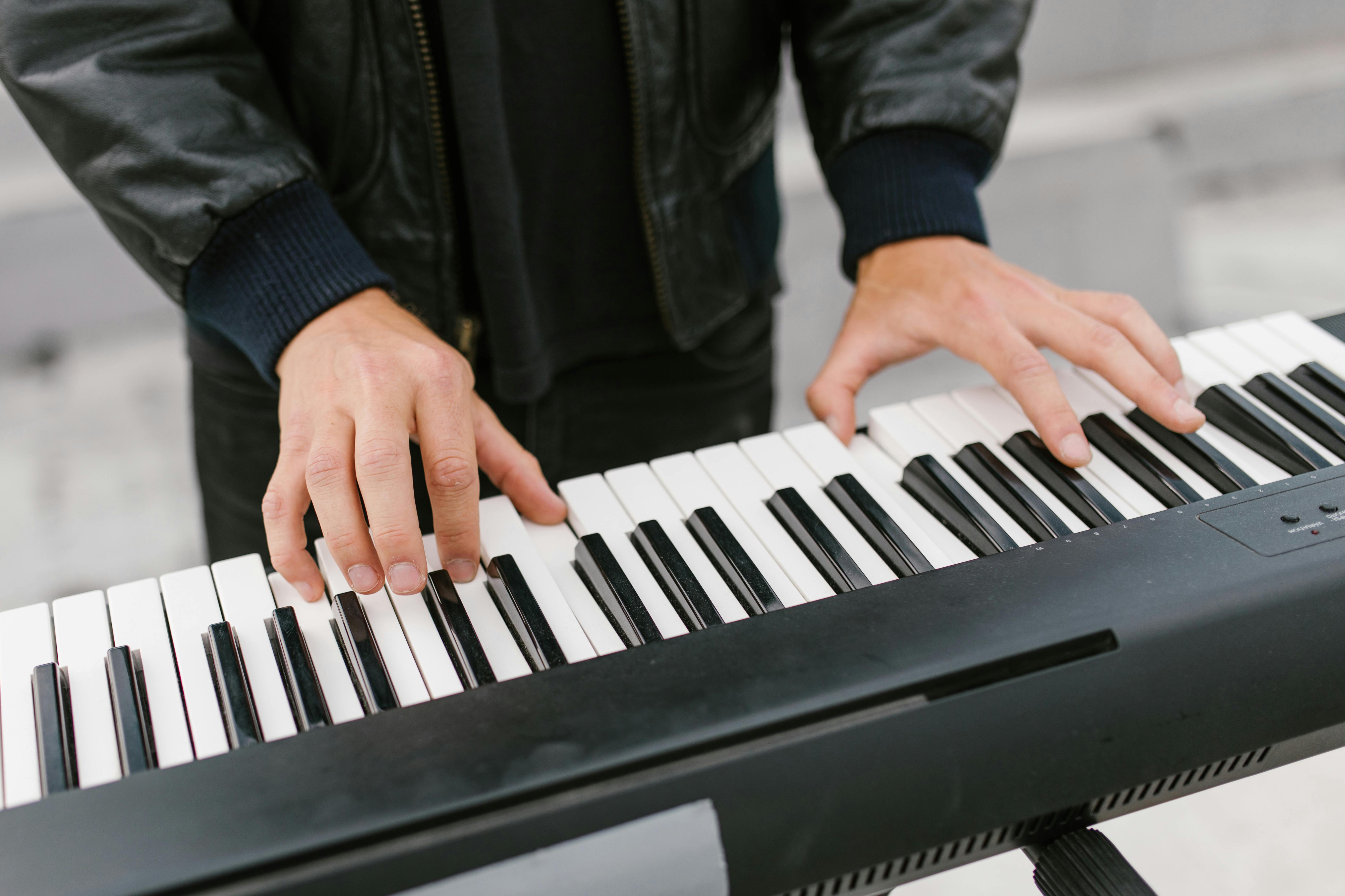 A Person in Black Jacket Playing the Electronic Keyboard · Free Stock Photo
