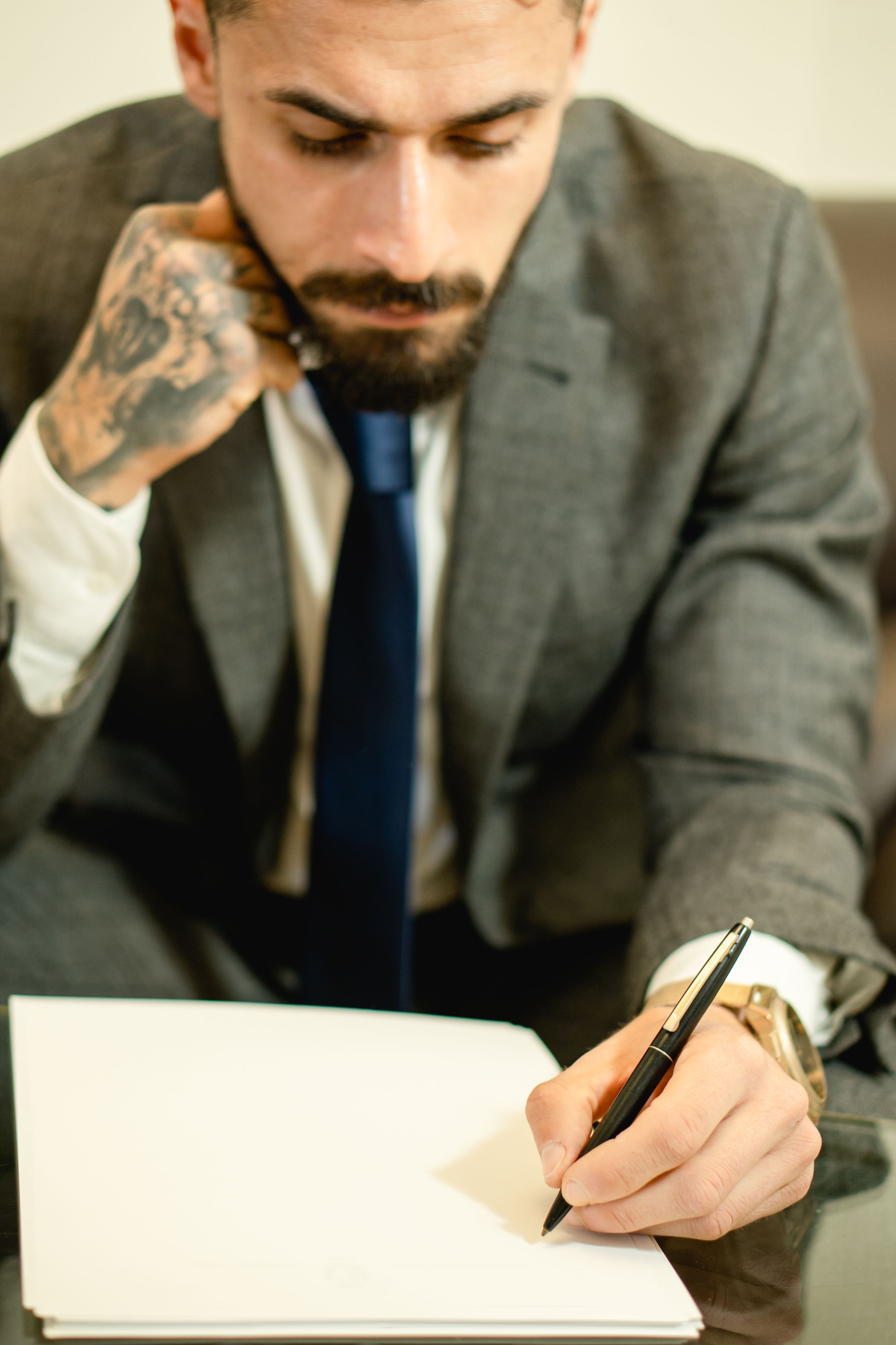 Person in Blue Denim Jacket Sitting on Chair While Writing · Free Stock ...