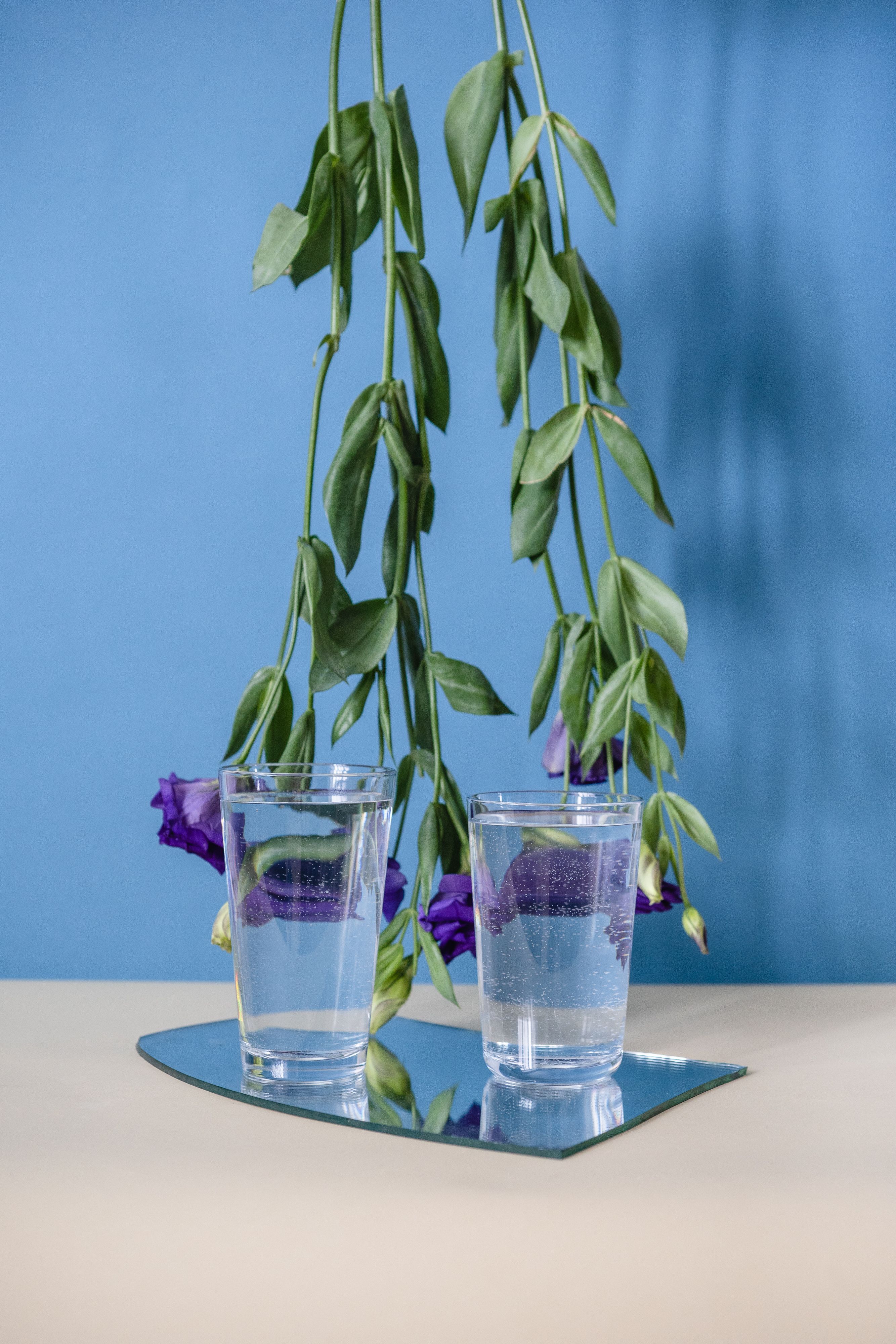 Clear Drinking Glasses with Liquid on a Mirror · Free Stock Photo