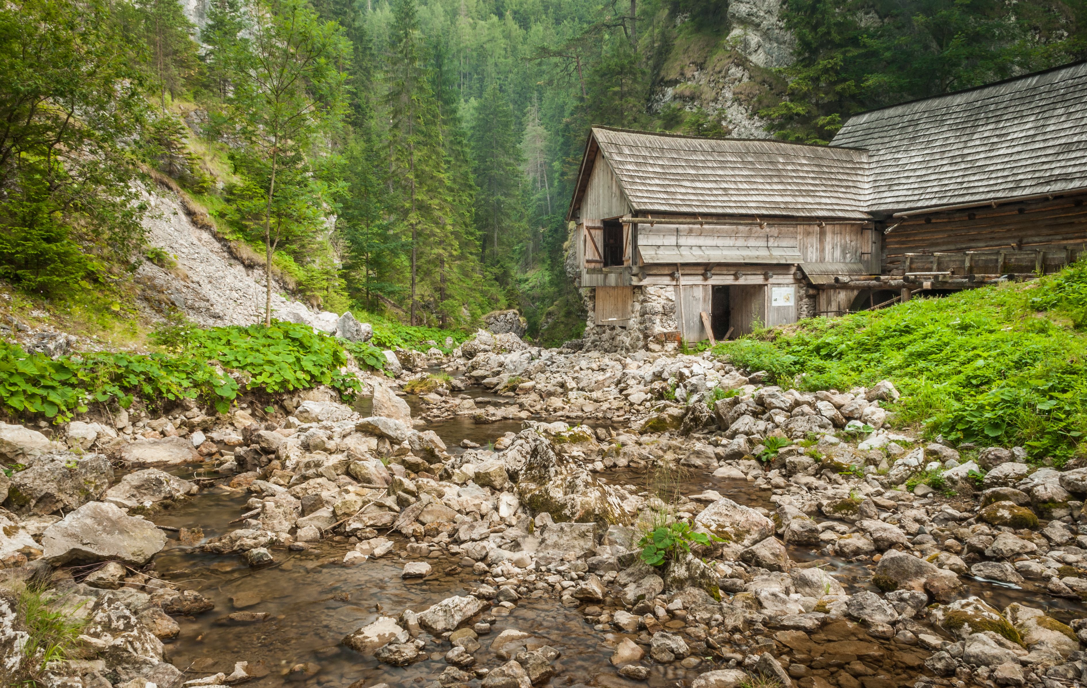 Rocks on a Stream Near a Wooden House · Free Stock Photo
