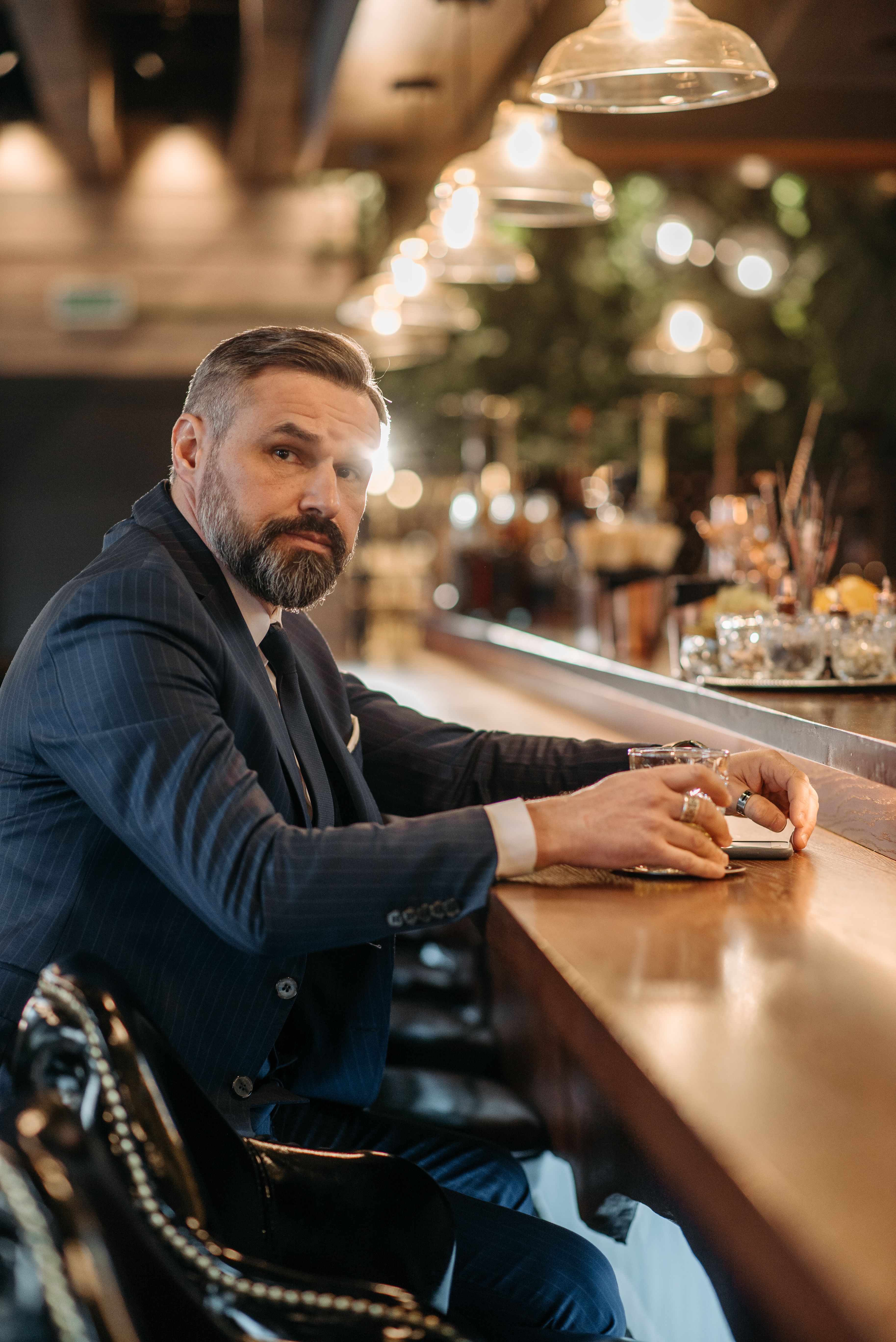 A Businessman in a Suit Waiting at a Bar Counter · Free Stock Photo