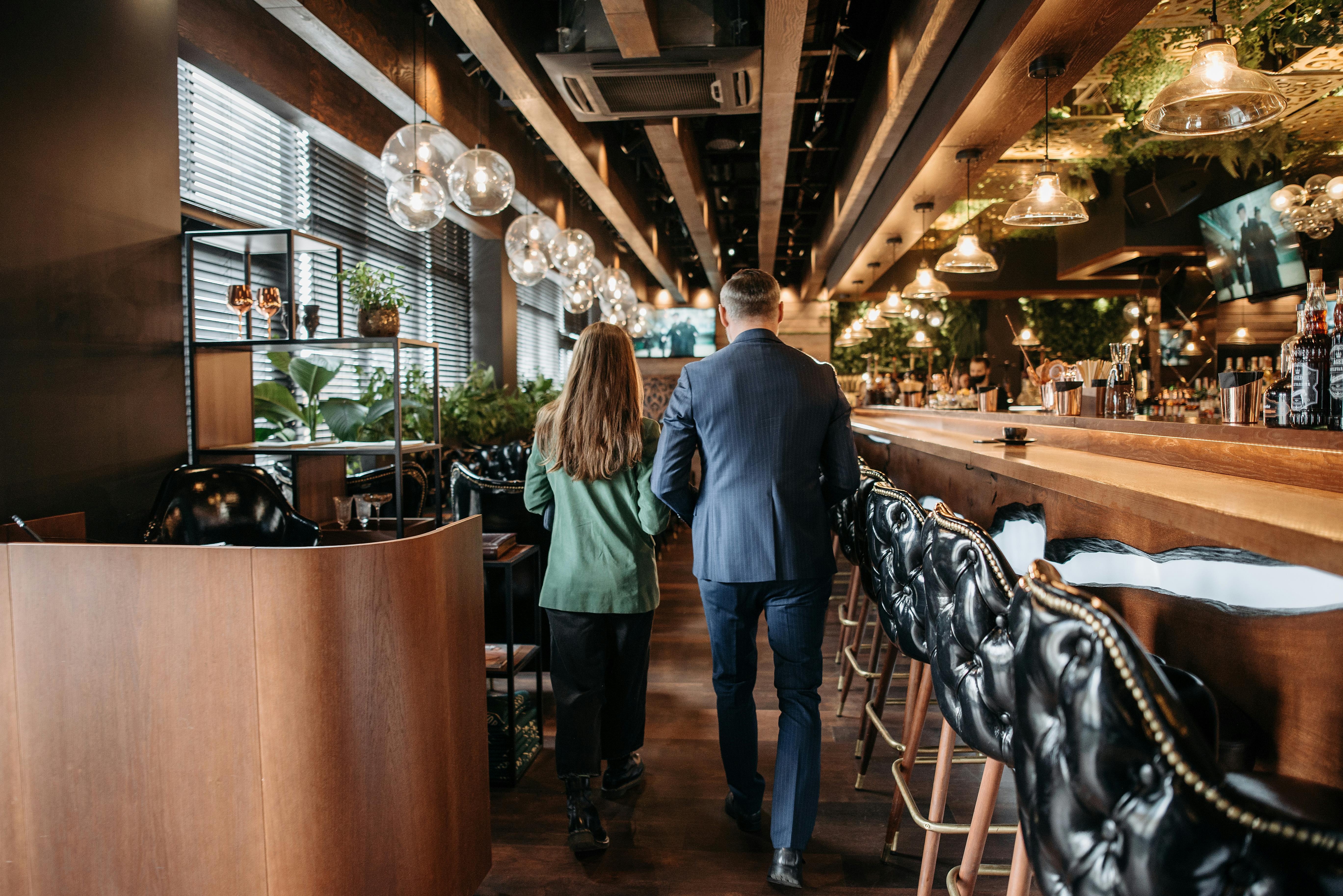Man and Woman Walking Beside the Bar Counter · Free Stock Photo