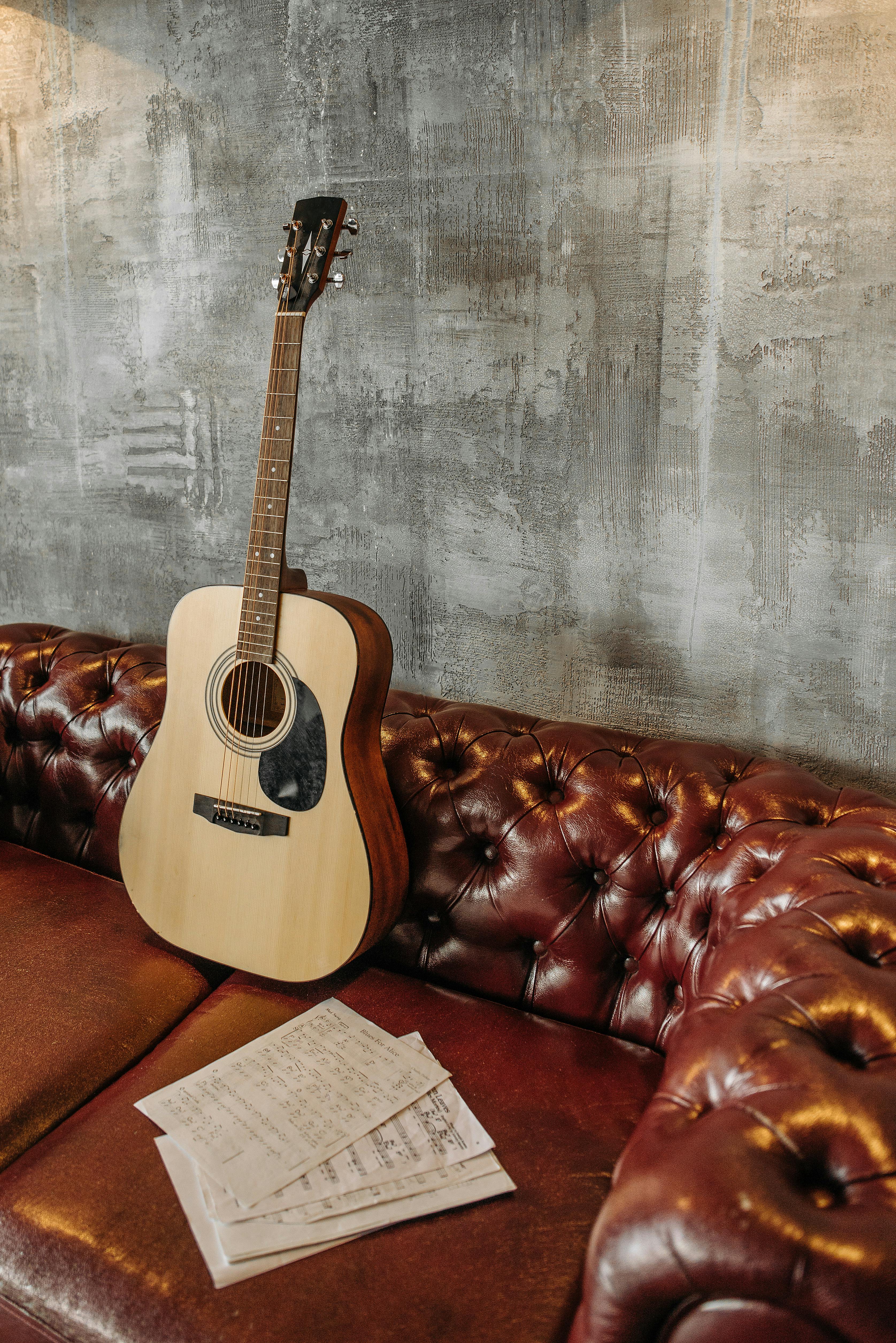 Brown Acoustic Guitar on Brown Leather Couch · Free Stock Photo