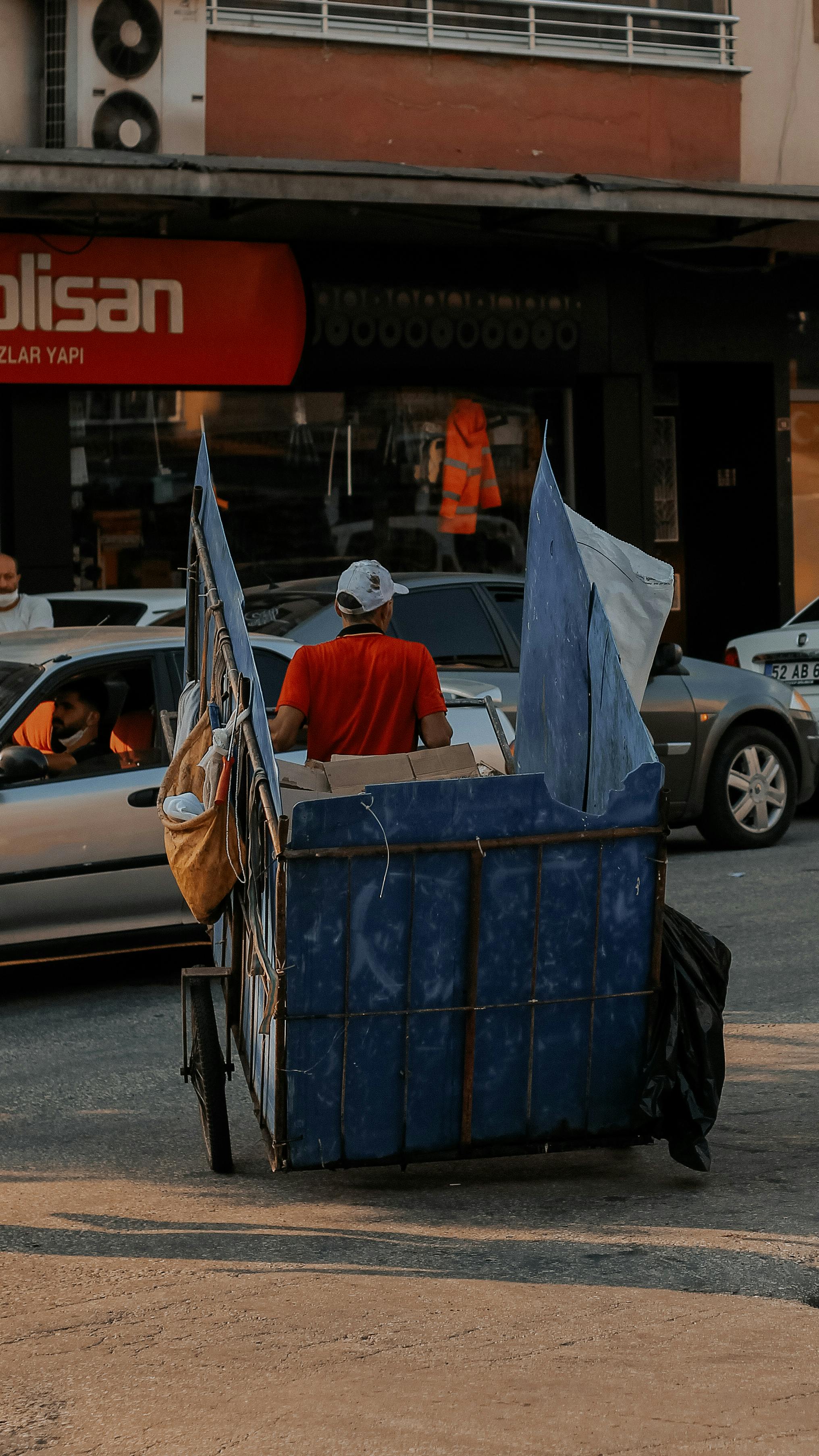 Unrecognizable man carrying trash can on street · Free Stock Photo