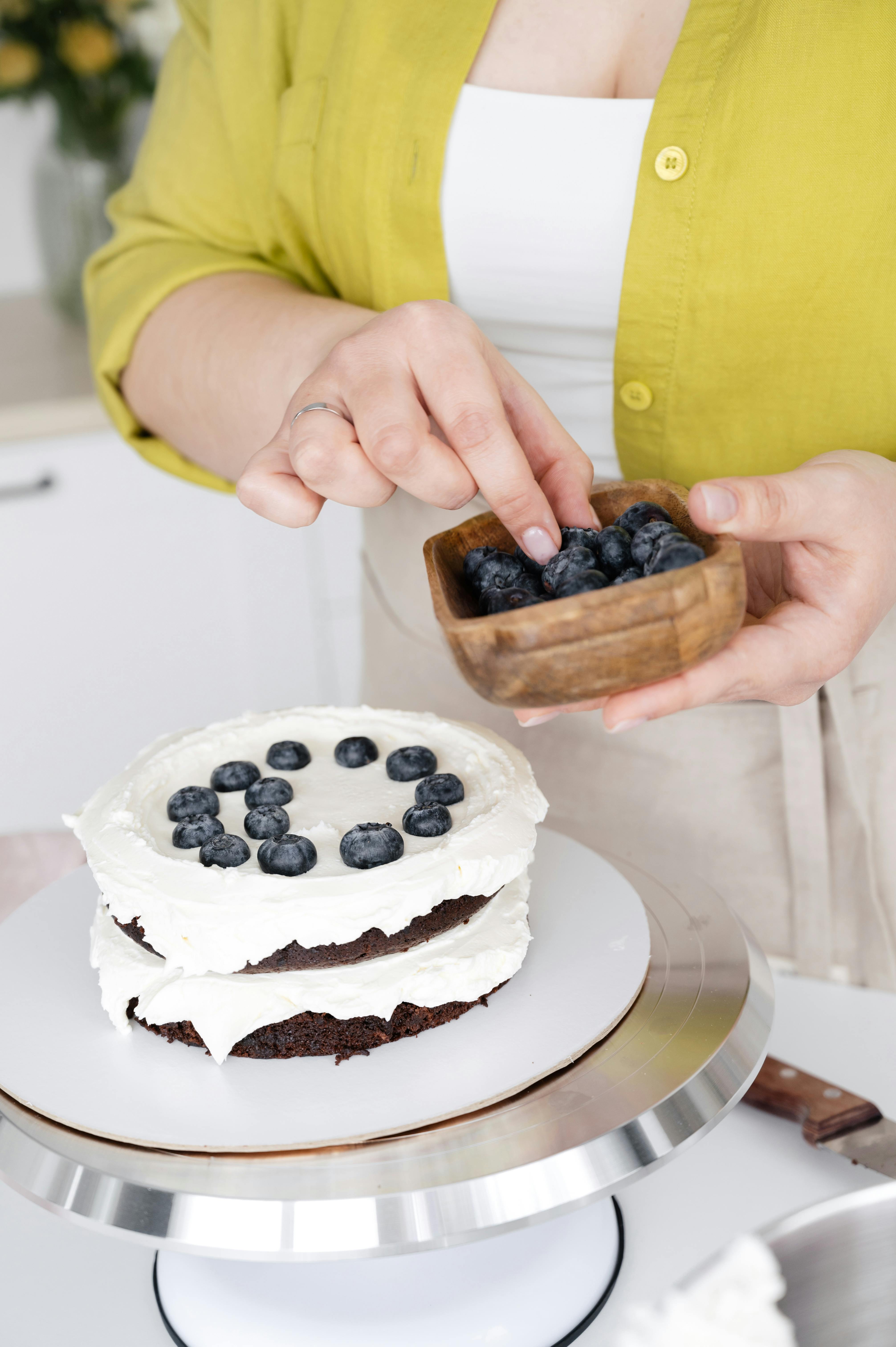 Crop cook decorating cake with berries · Free Stock Photo