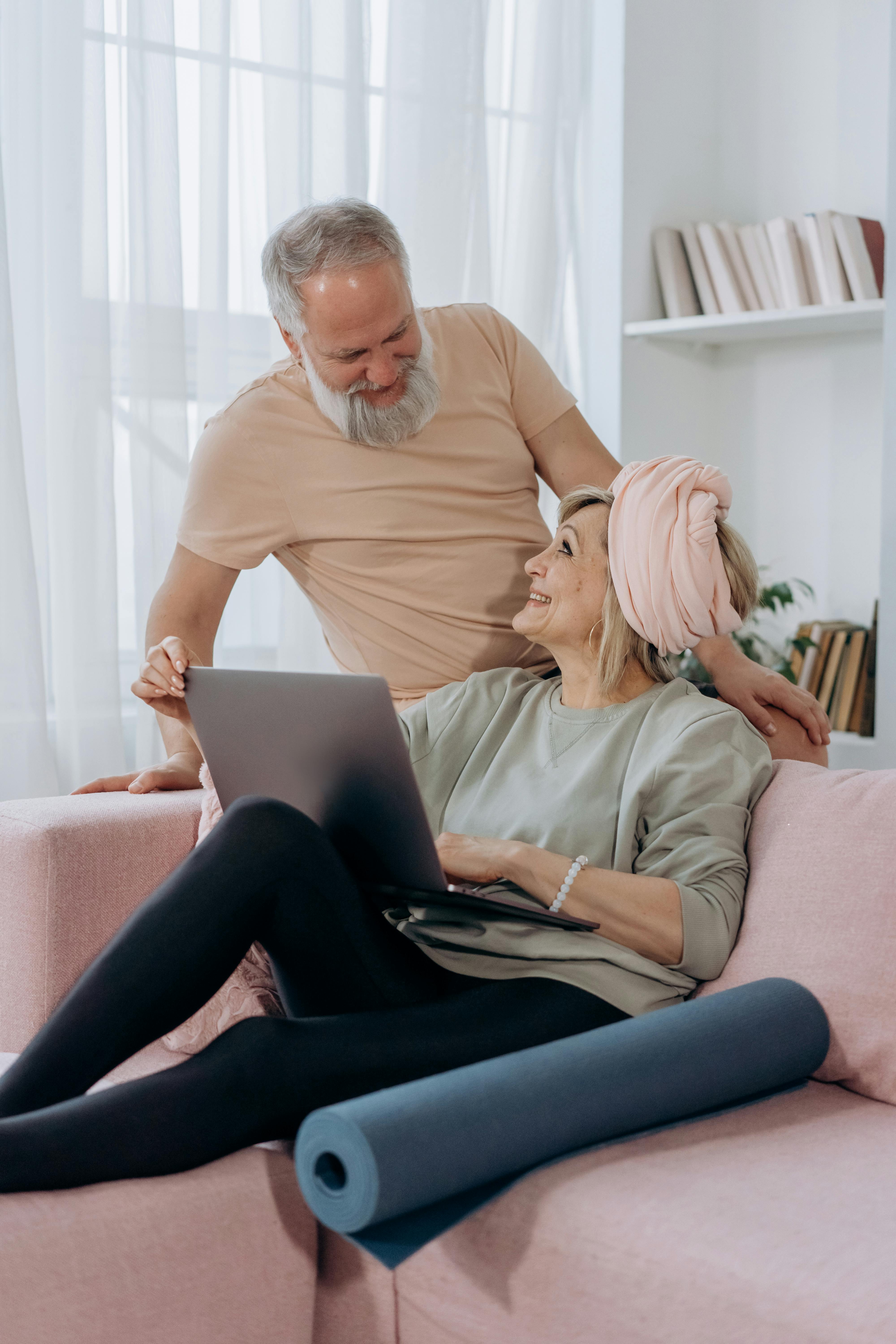 An Elderly Woman Sitting on the Sofa while Using a Laptop · Free Stock ...
