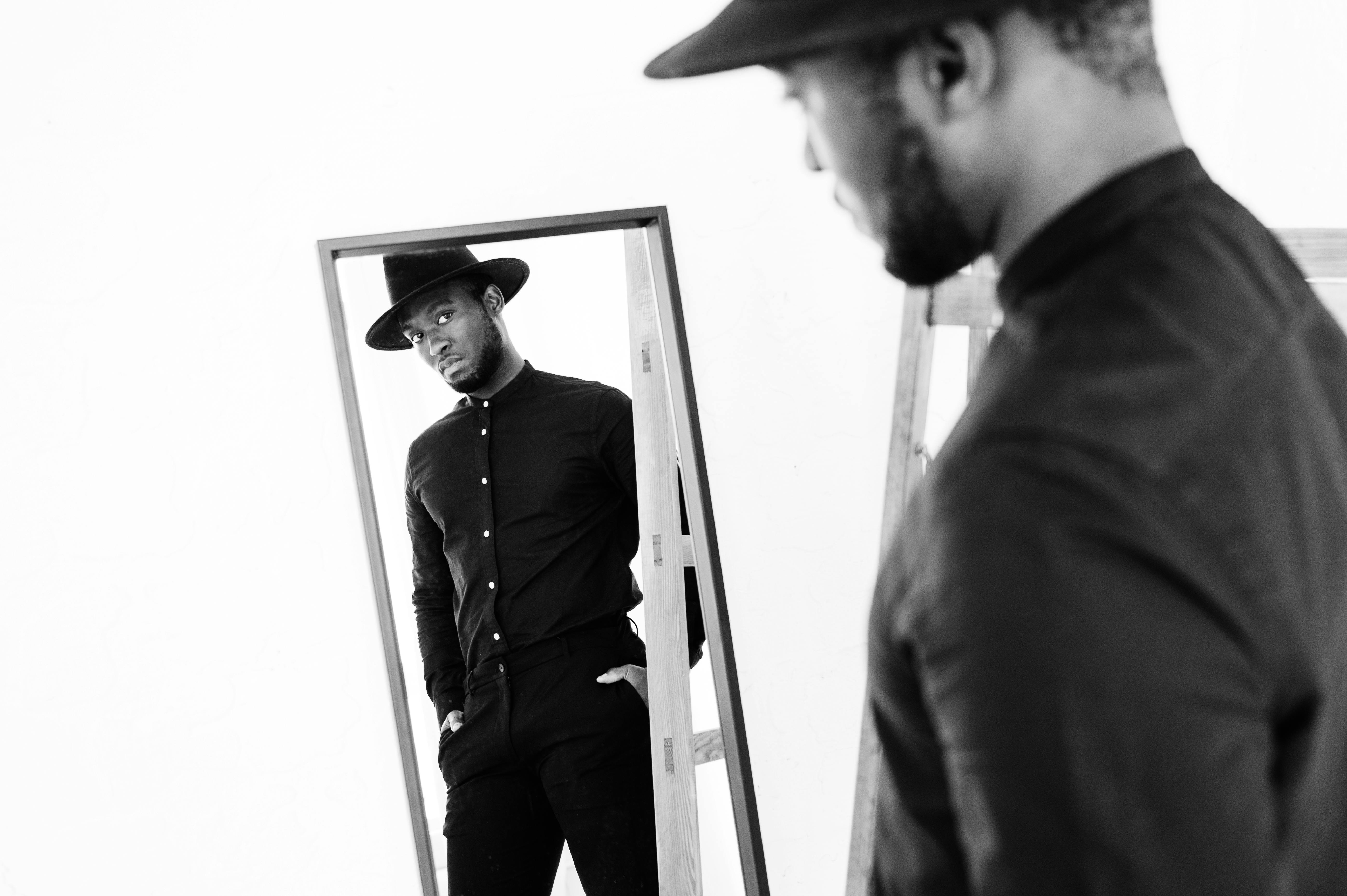 Serious ethnic man looking in mirror · Free Stock Photo