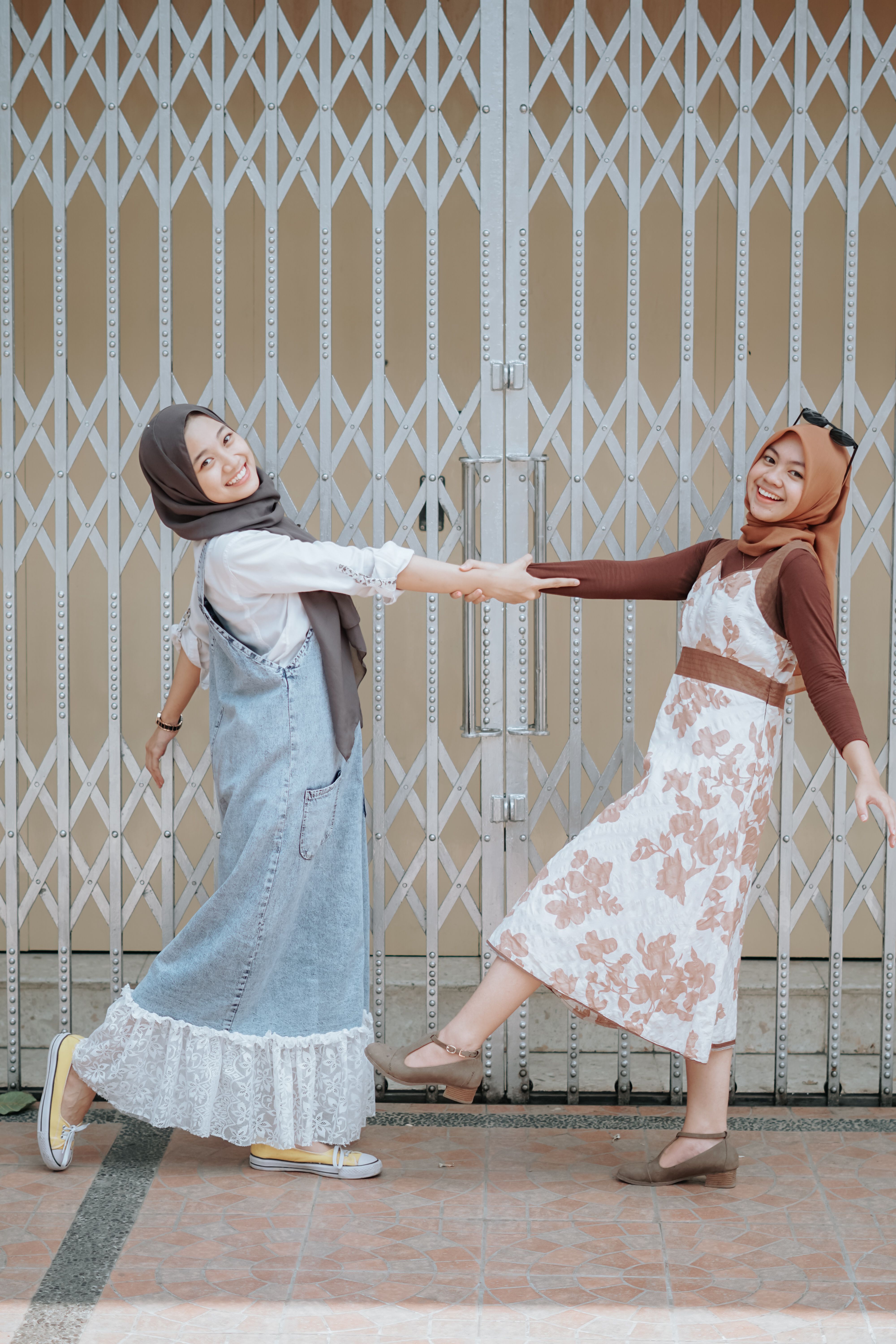 Women Holding Hands While Posing · Free Stock Photo