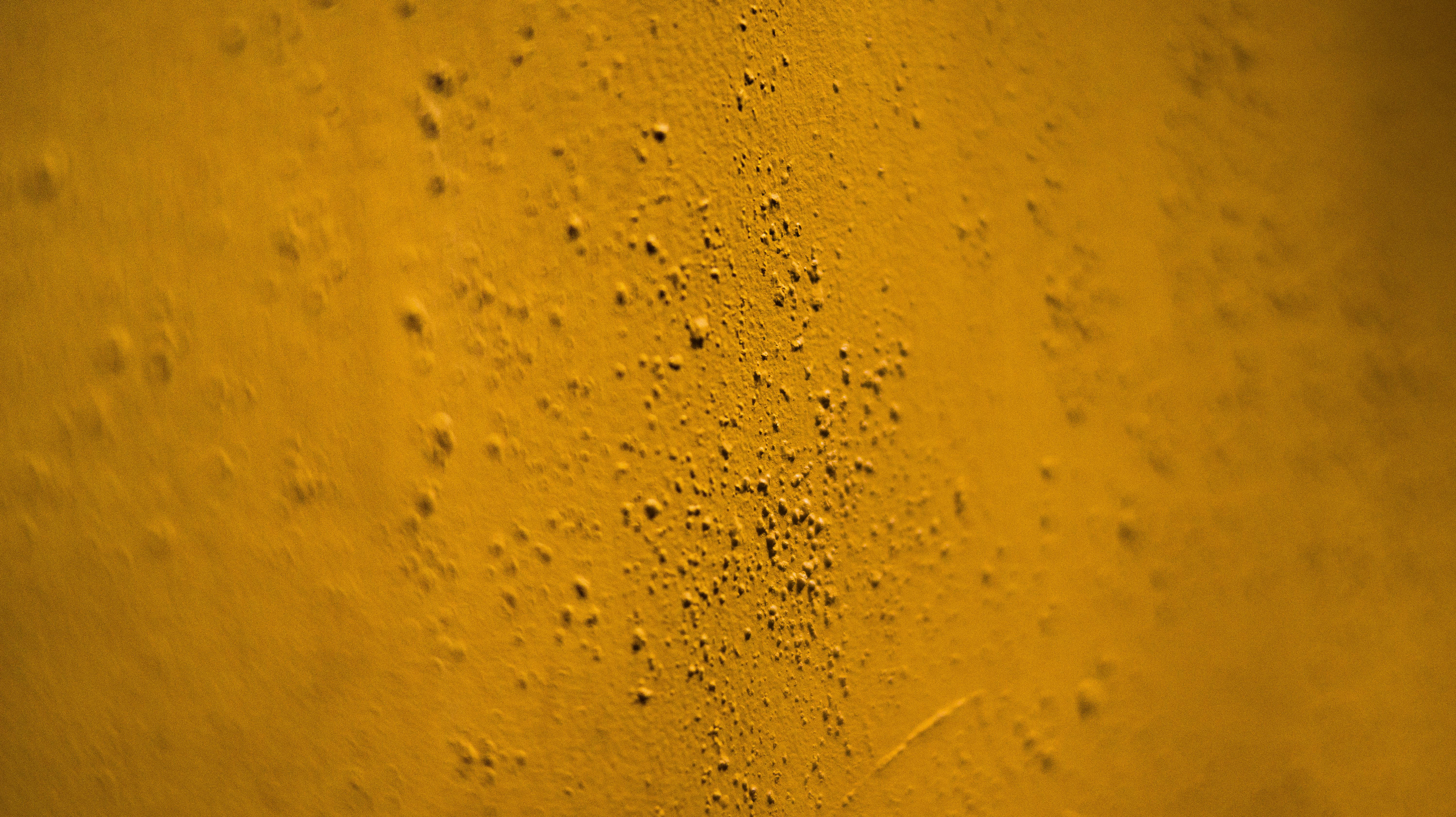 Uneven yellow wall with irregular grains · Free Stock Photo