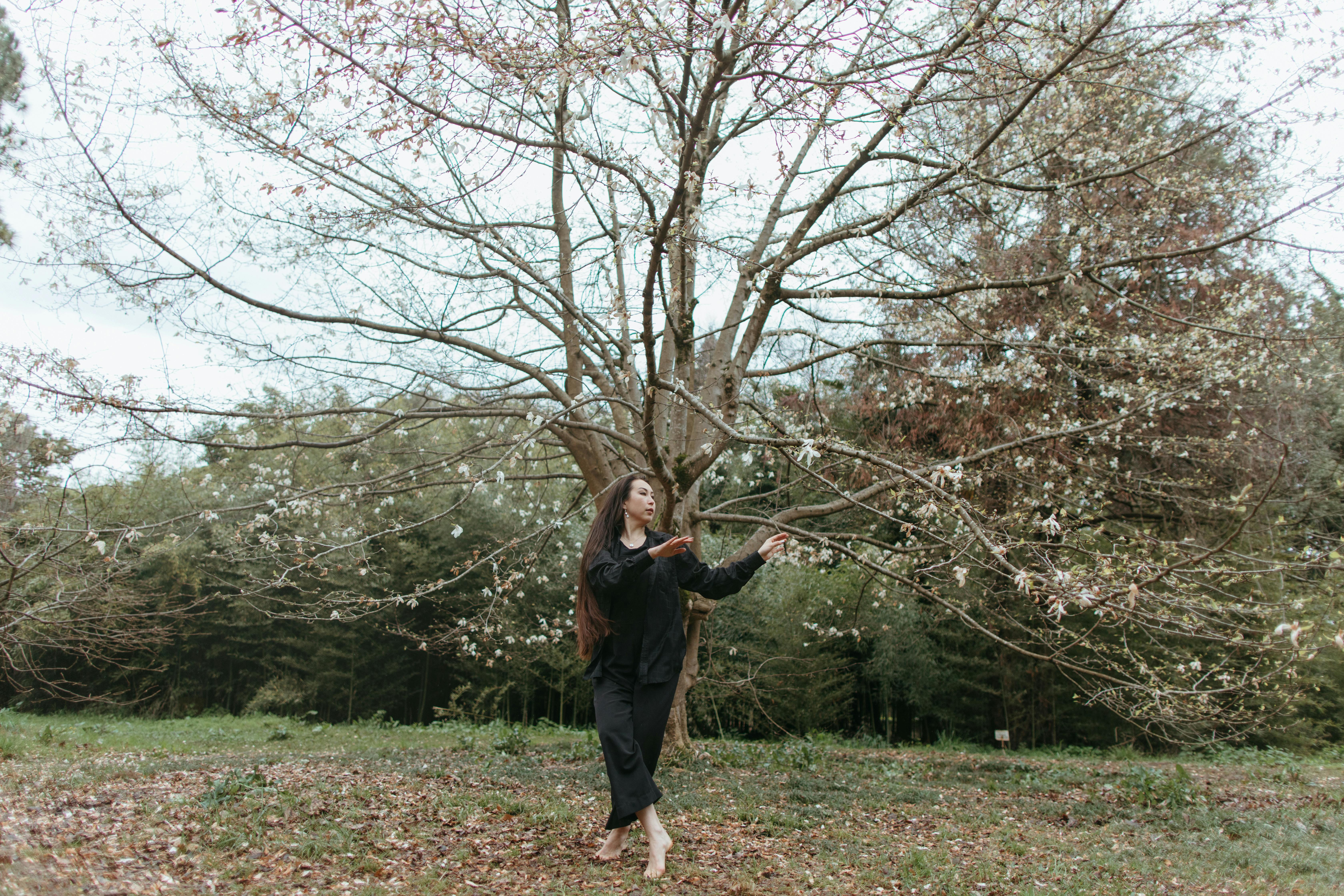 A Woman Standing In Front A Tree Looking Afar · Free Stock Photo