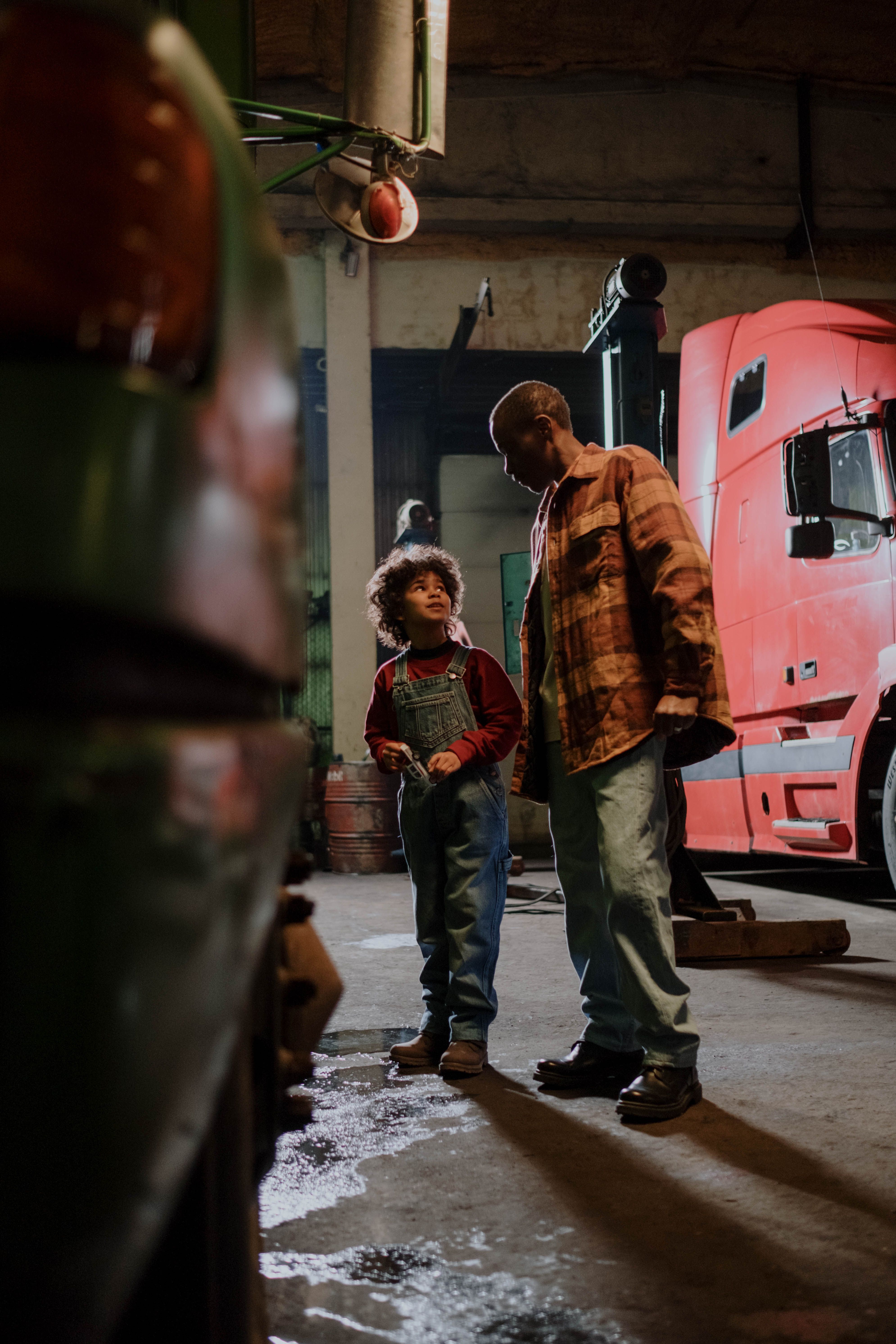 A Father with a Child Standing in a Garage · Free Stock Photo