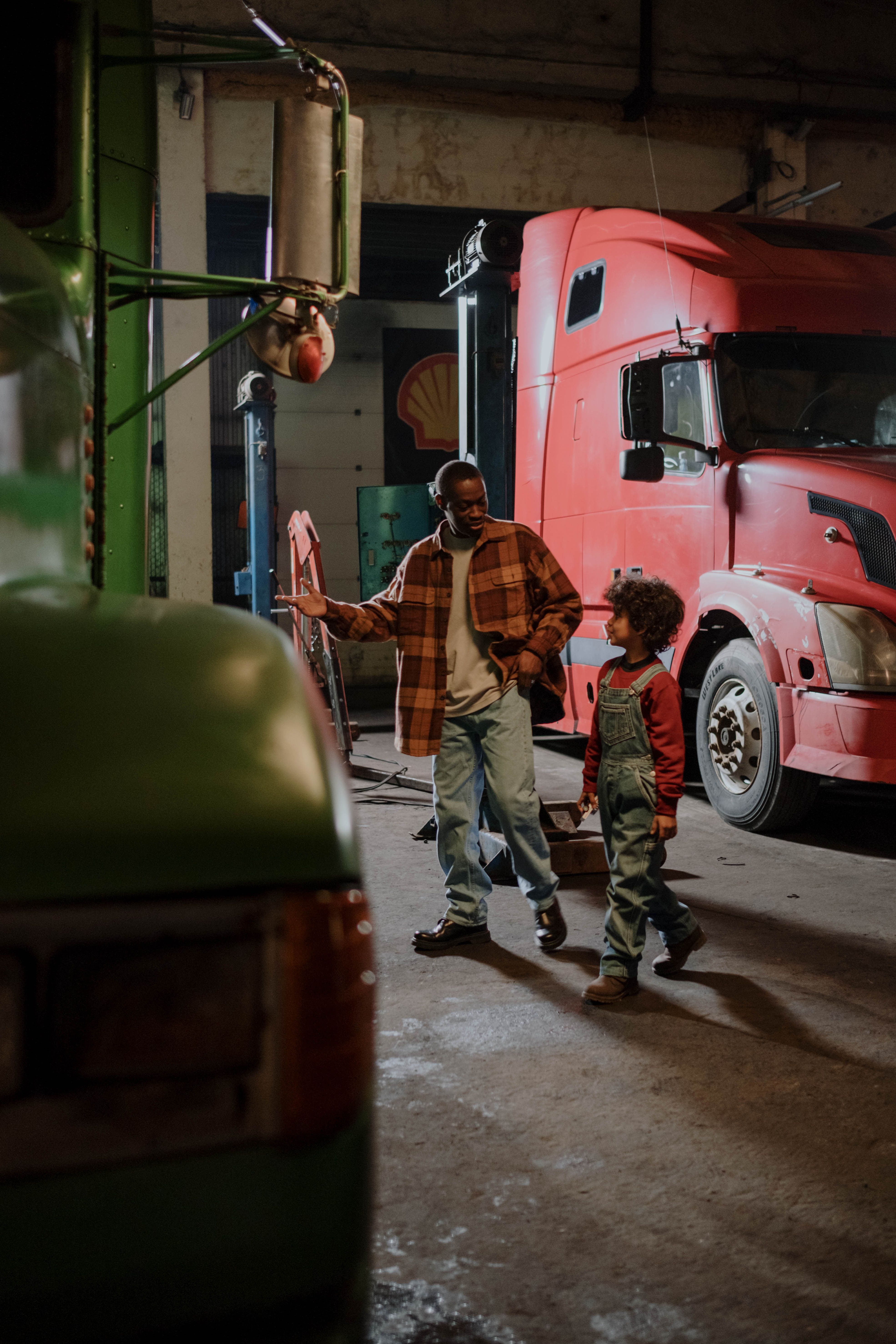 A Man and a Kid Standing Near Red Truck · Free Stock Photo