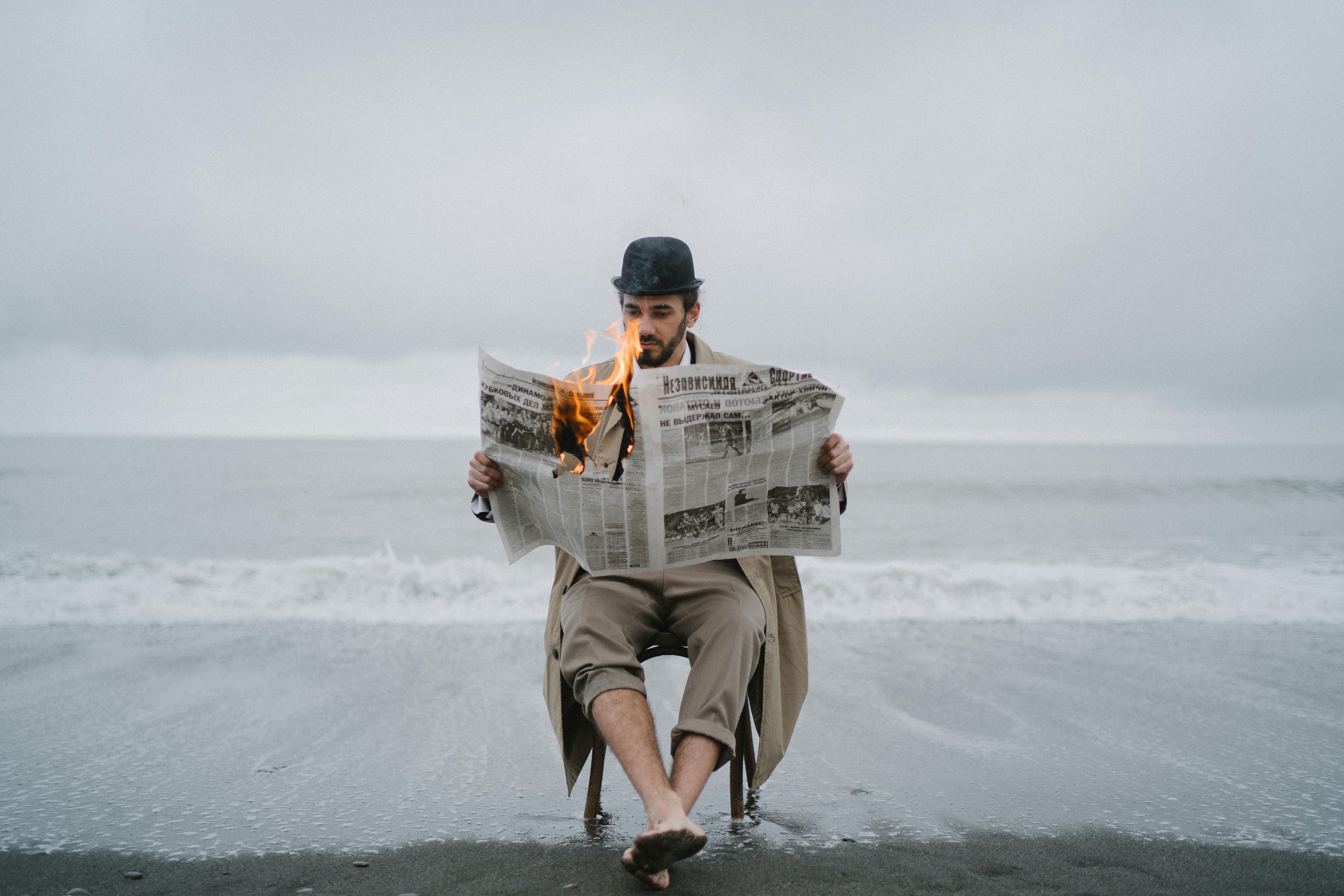 Man holding a Burning Newspaper · Free Stock Photo