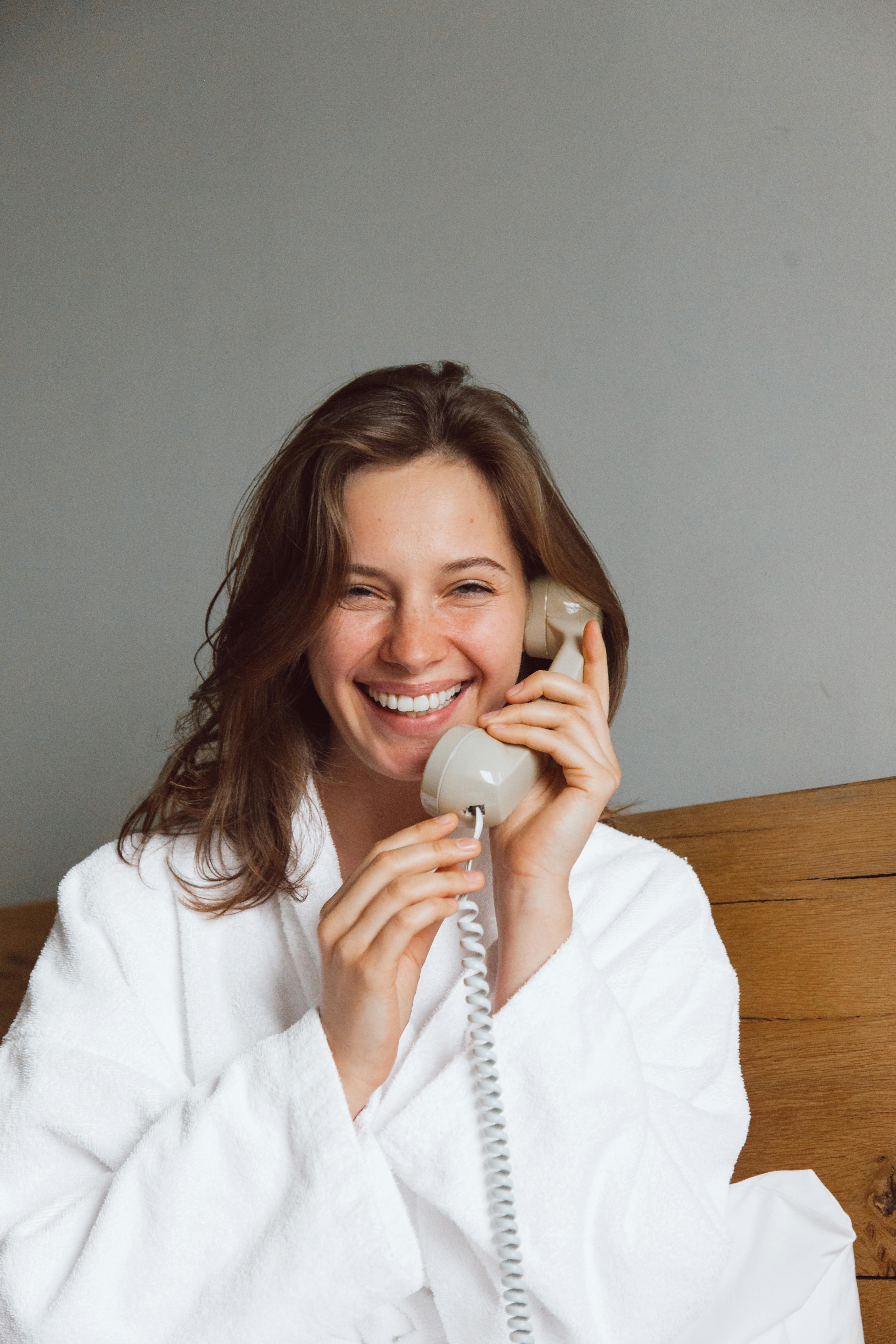 Woman Smiling Using Rotary Phone · Free Stock Photo