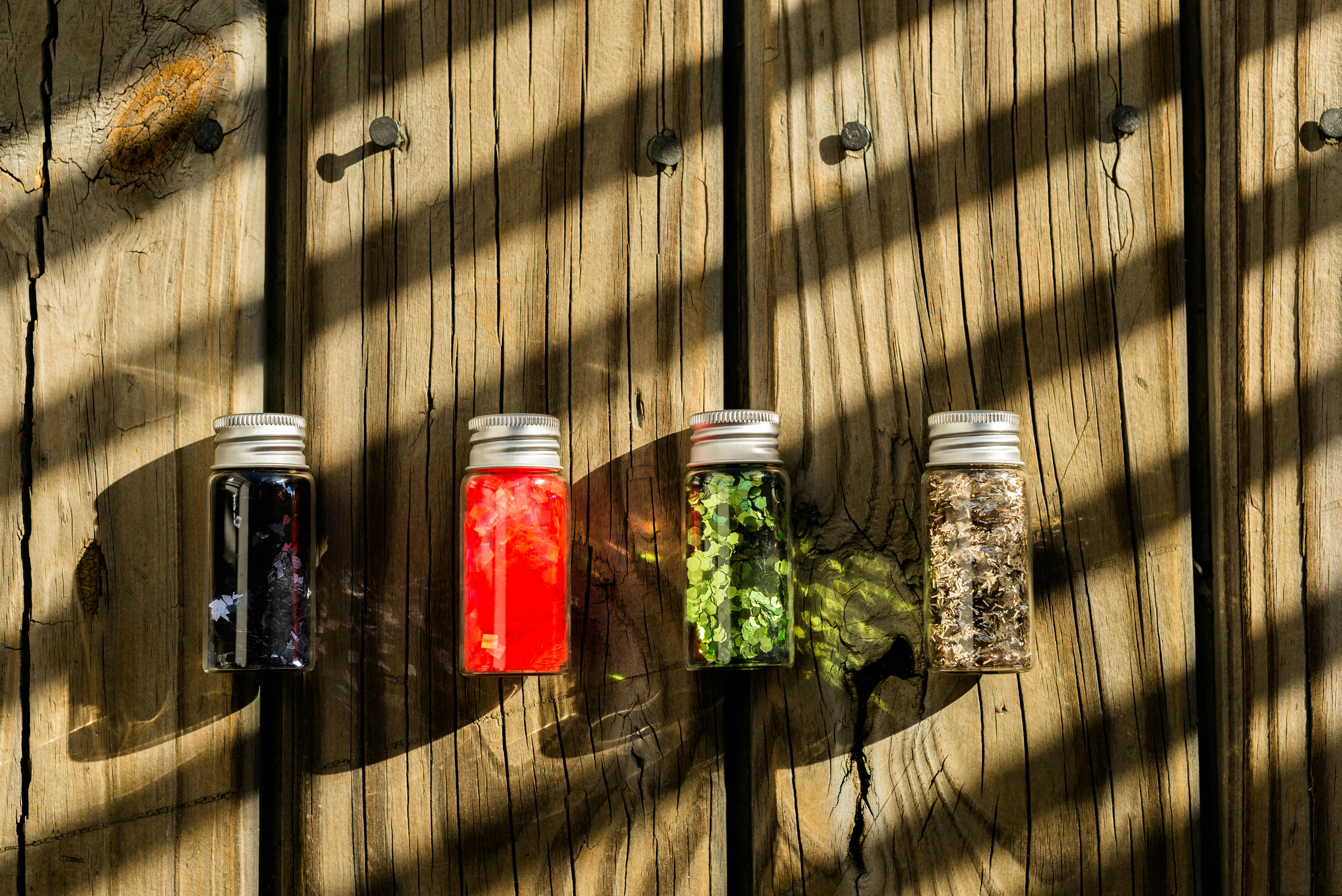 Several Assorted-color Glass Bottles on Table · Free Stock Photo