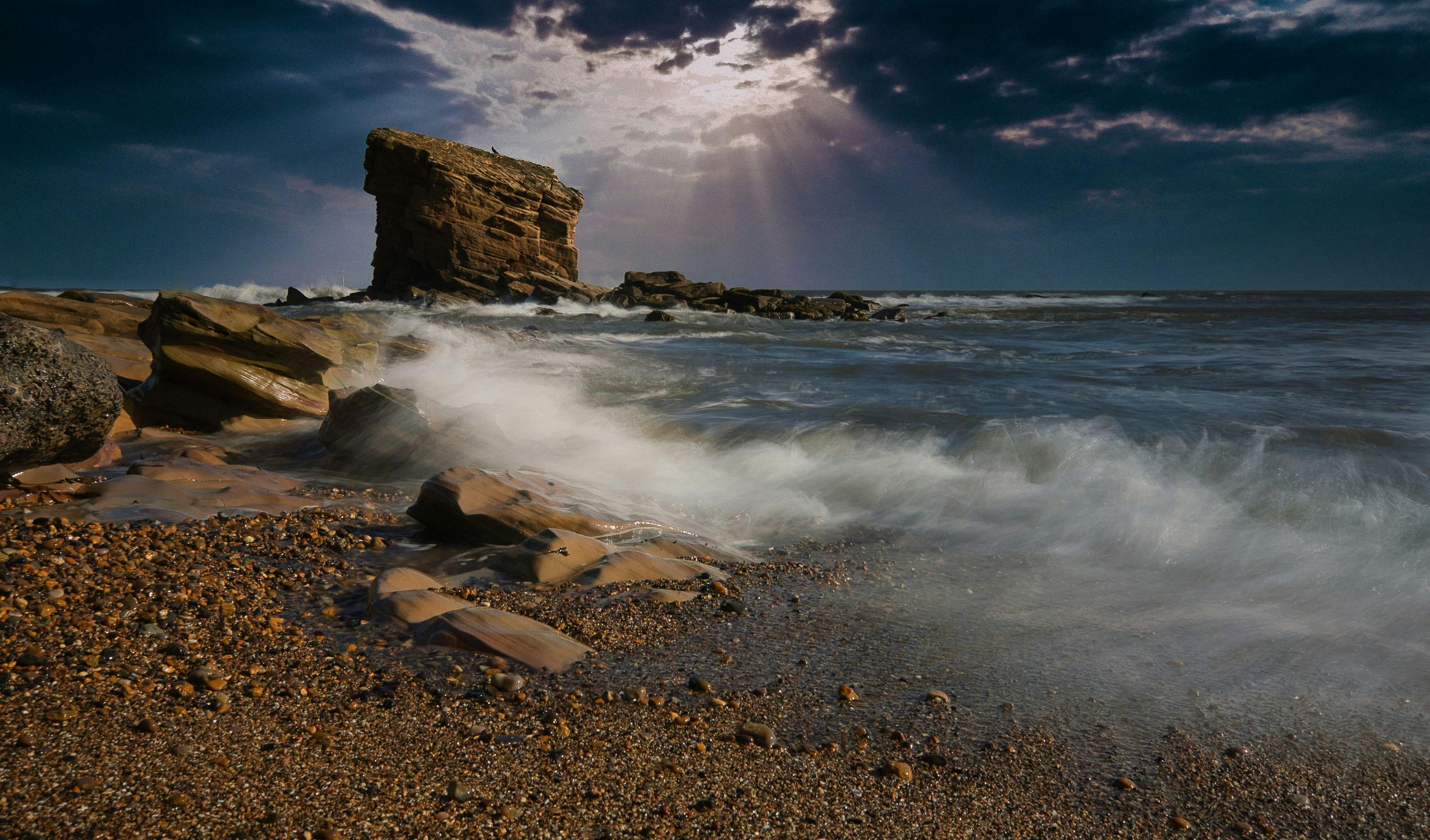 A Rock Formation on the Sea near the Shore · Free Stock Photo