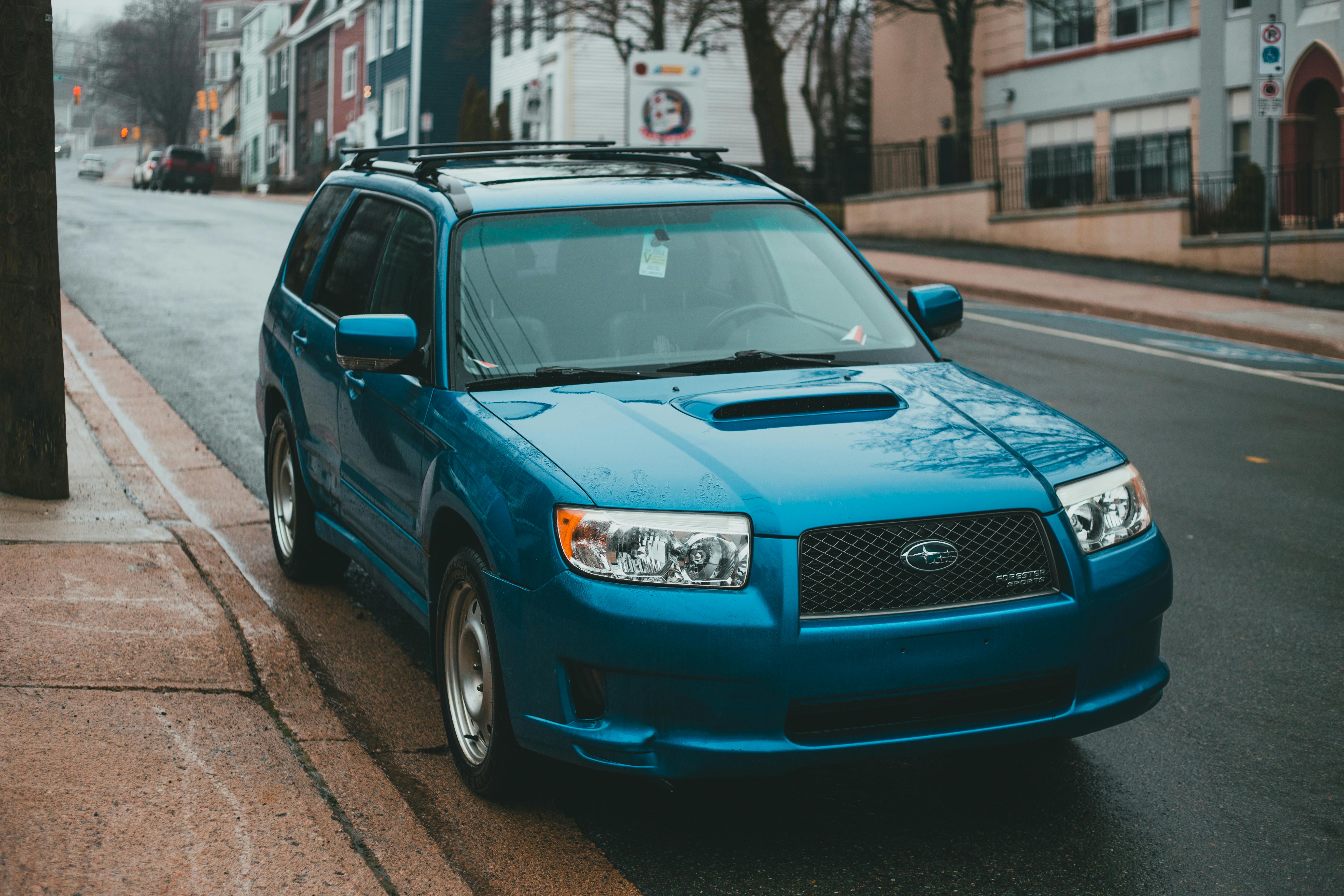 Blue car parked on street in cloudy day · Free Stock Photo