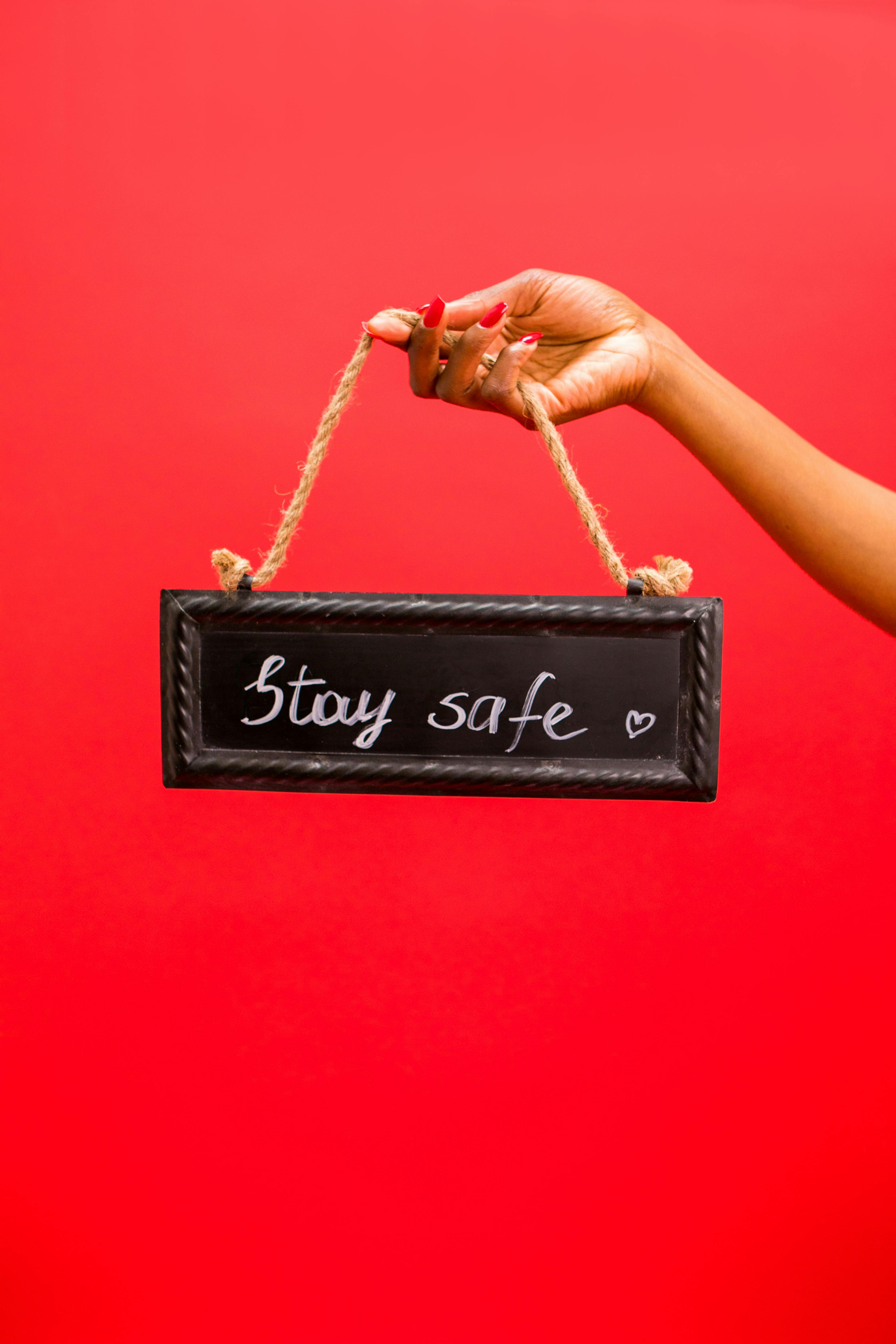 A Person Holding a Stay Safe Sign Board · Free Stock Photo