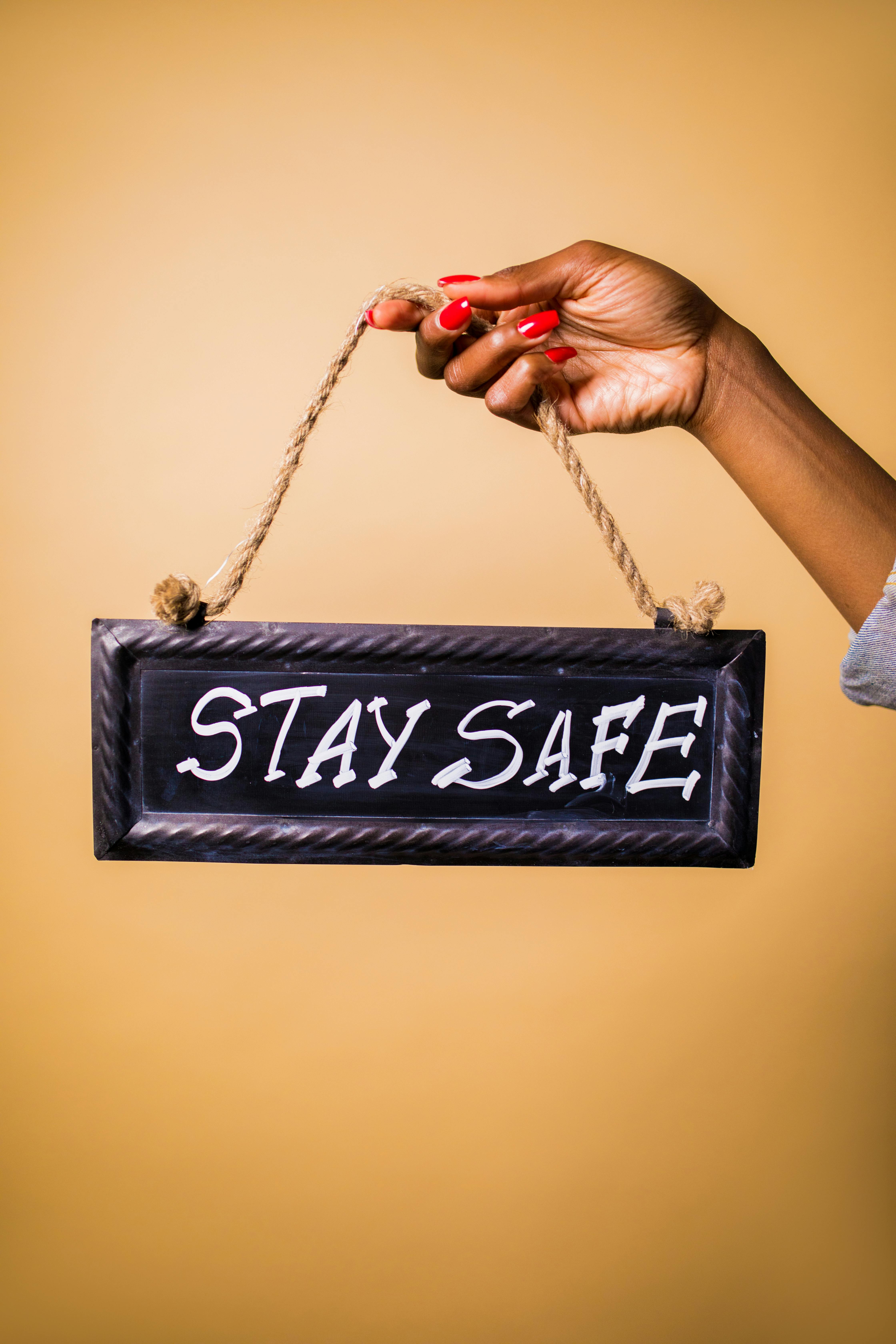 A Person Holding a Stay Safe Sign Board · Free Stock Photo