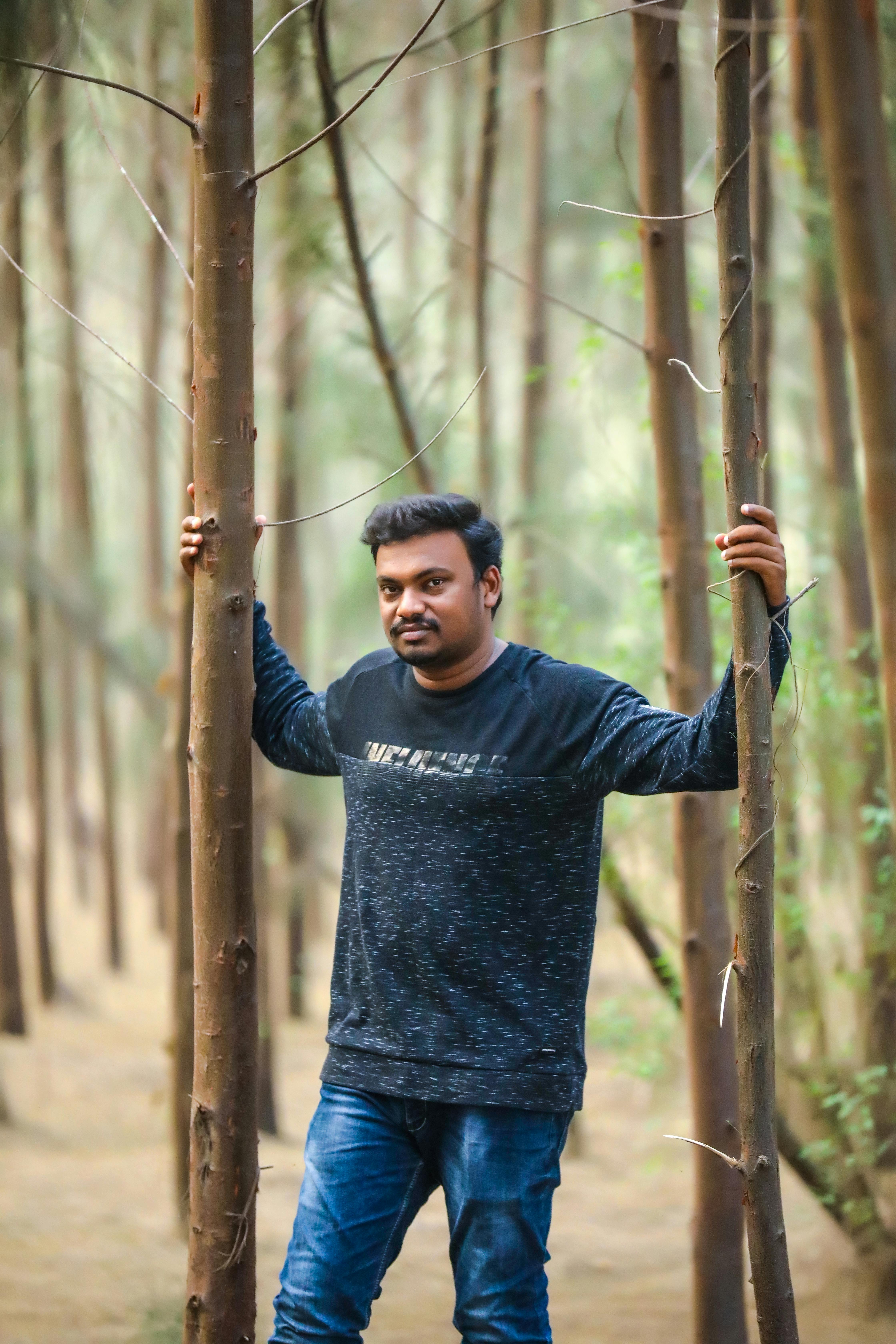 Selective Focus Photo of a Man Holding Two Trees · Free Stock Photo