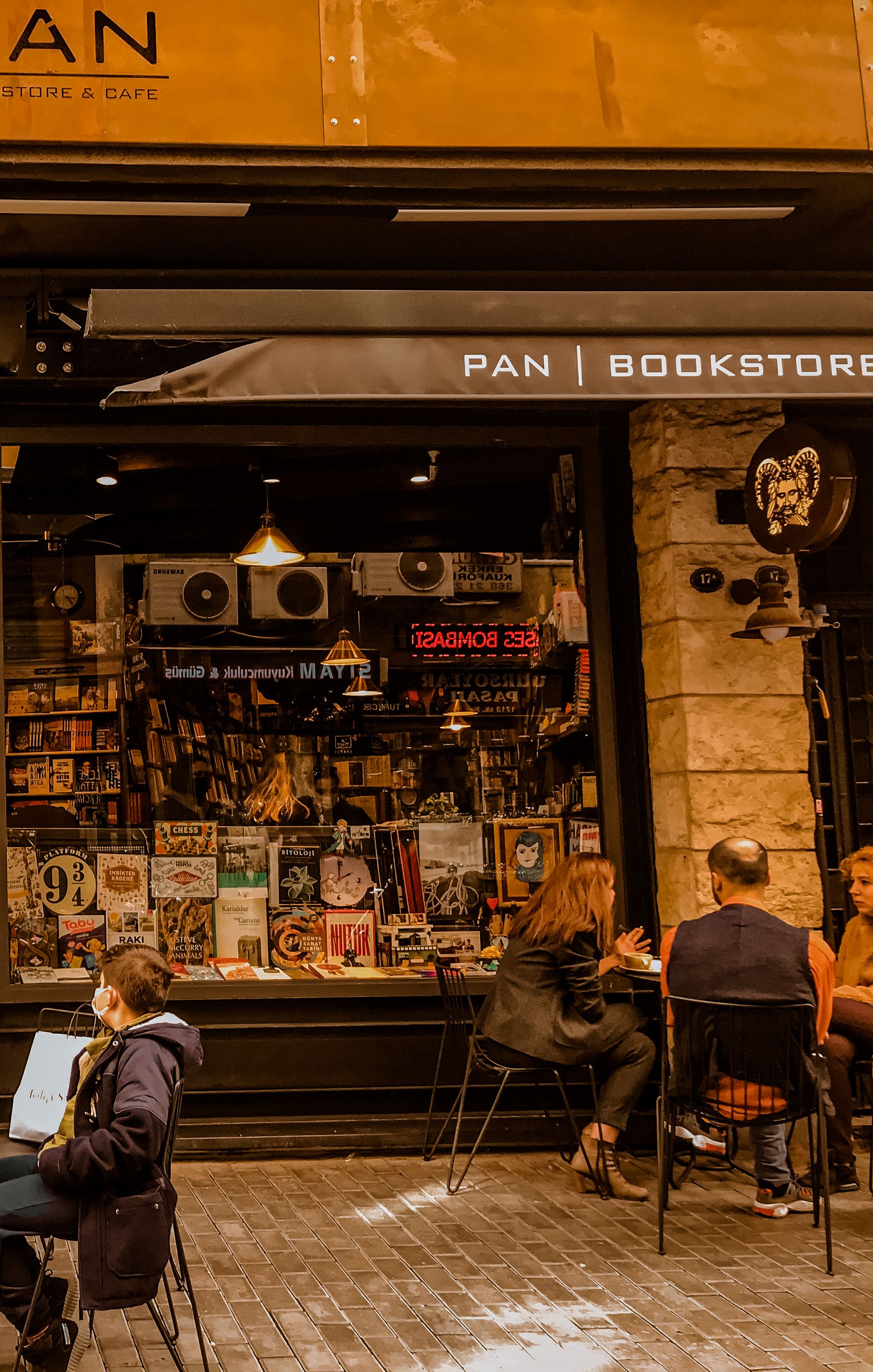 People Sitting on Chairs in Front of a Bookstore Café · Free Stock Photo