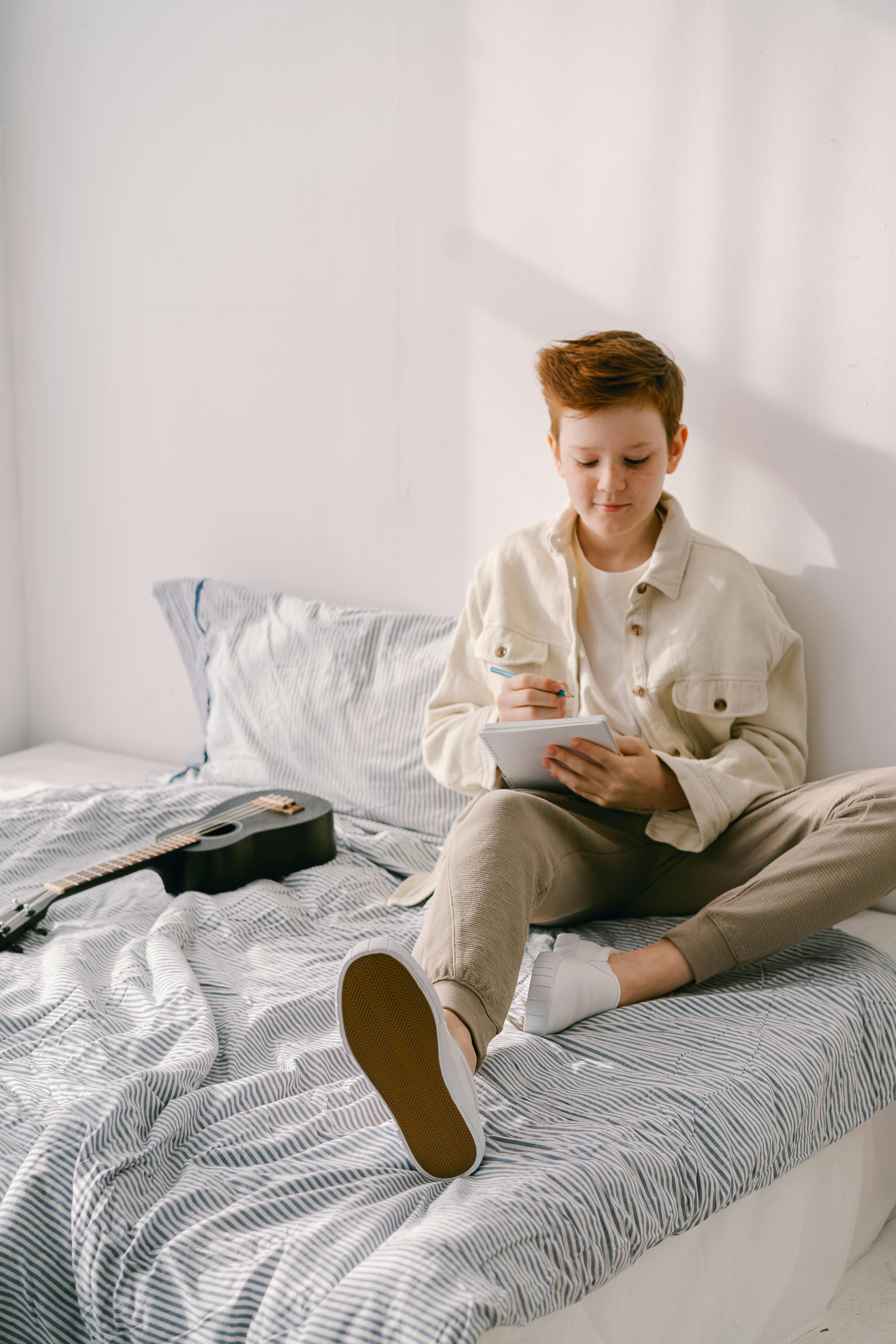 Boy writing down on Notebook · Free Stock Photo