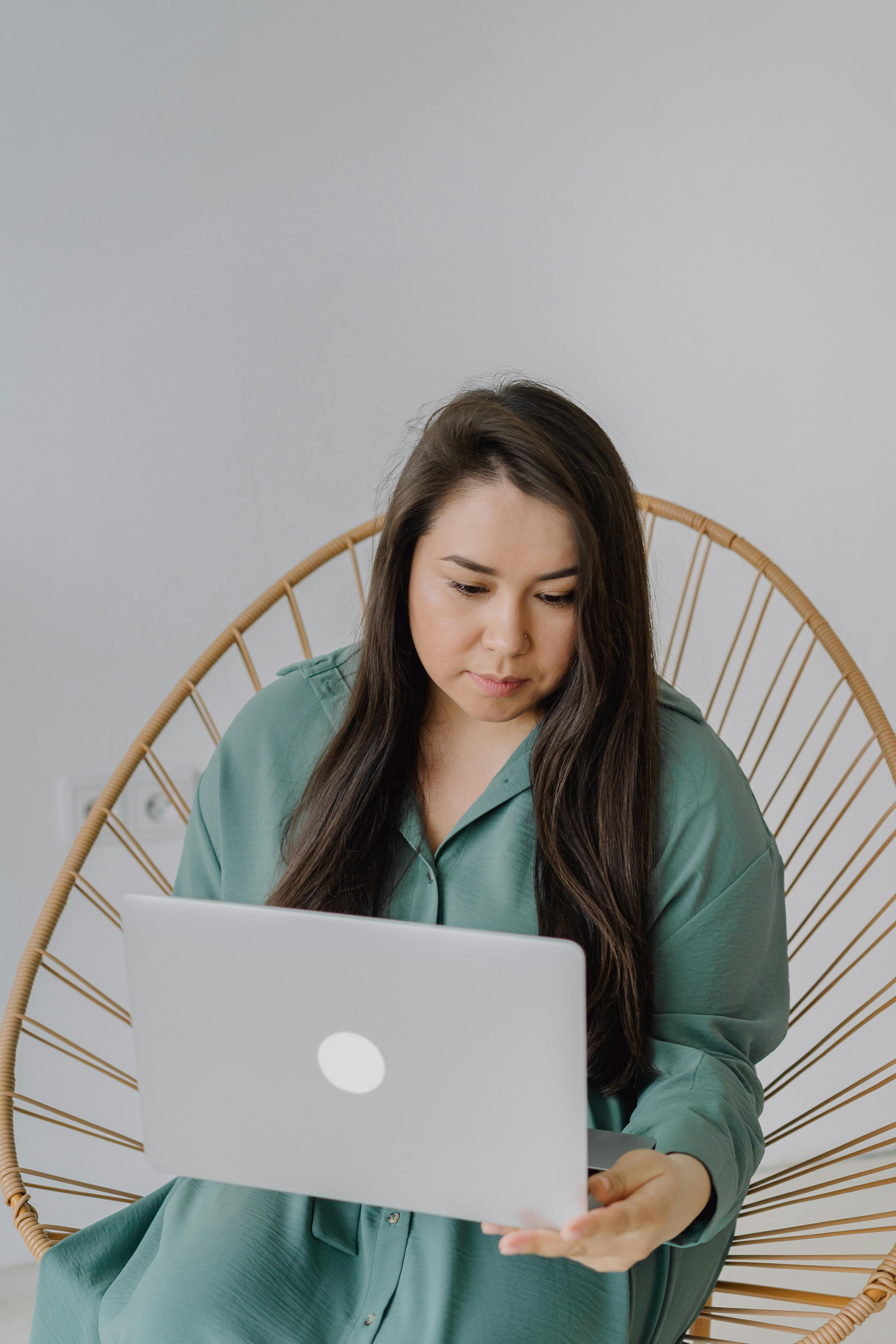 Woman in Green Dress Using Silver Laptop · Free Stock Photo