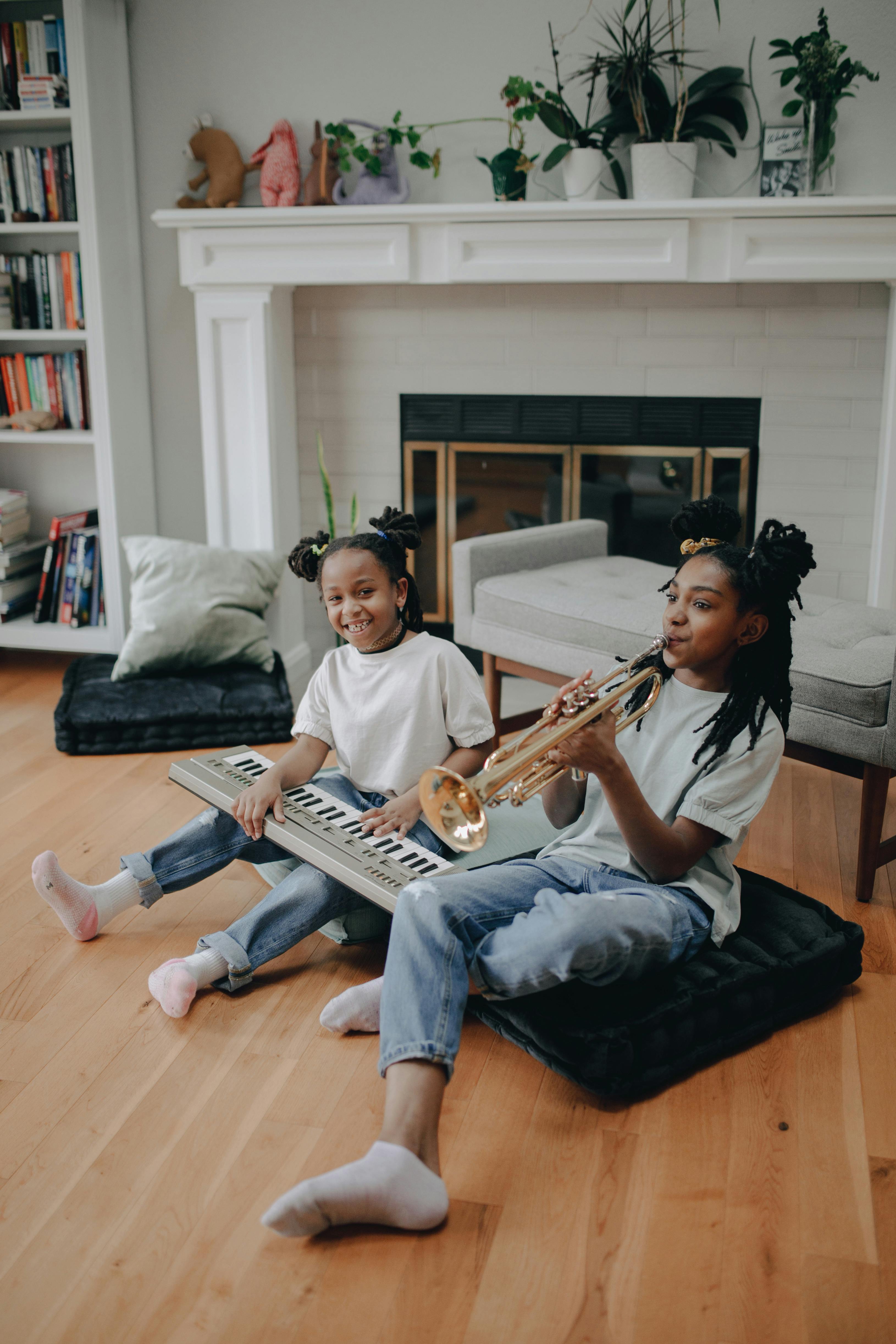 Two Girls Sitting on the Floor Playing Musical Instruments · Free Stock ...