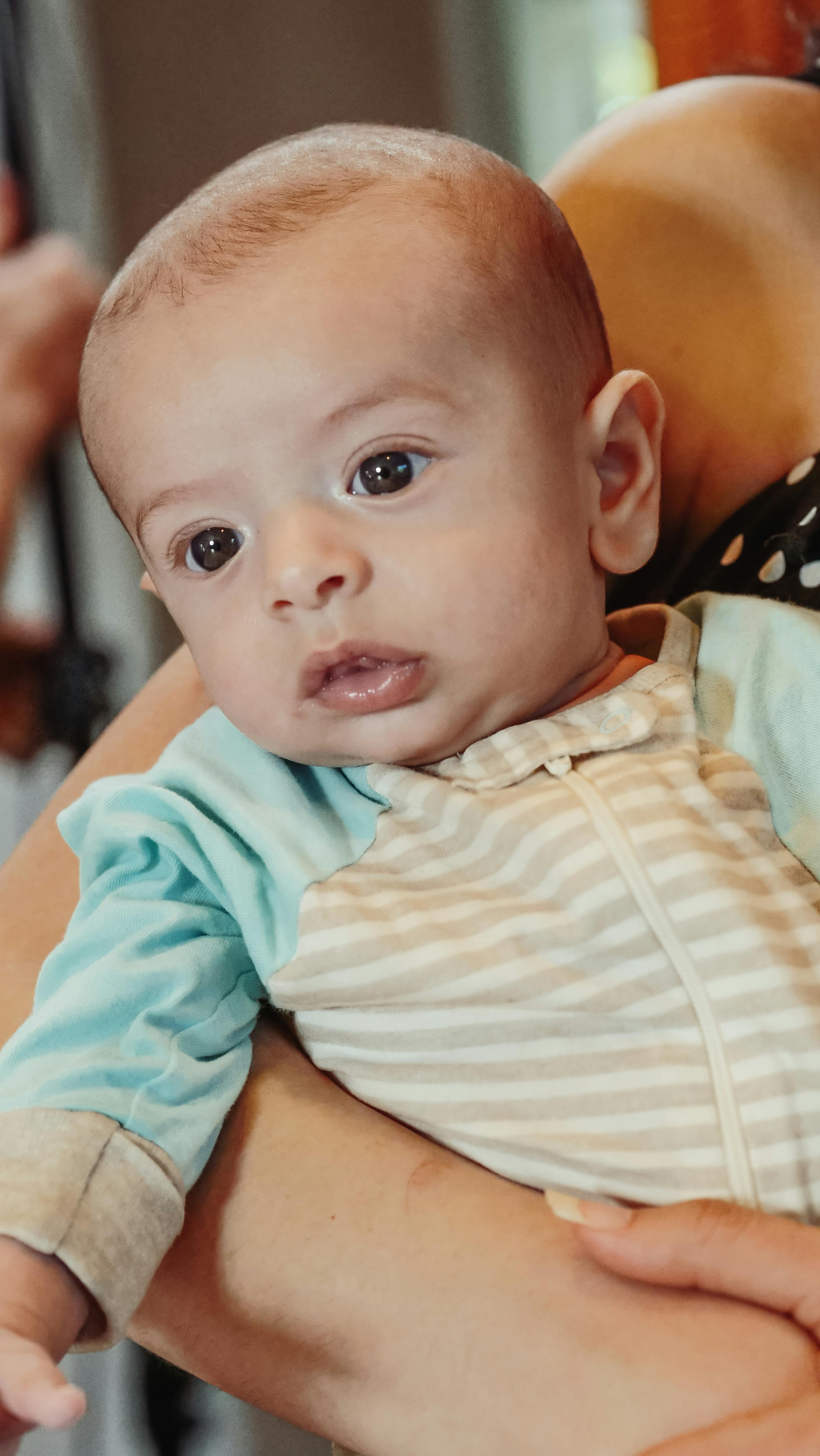 A Kid Squeezing the Face of a Baby · Free Stock Photo
