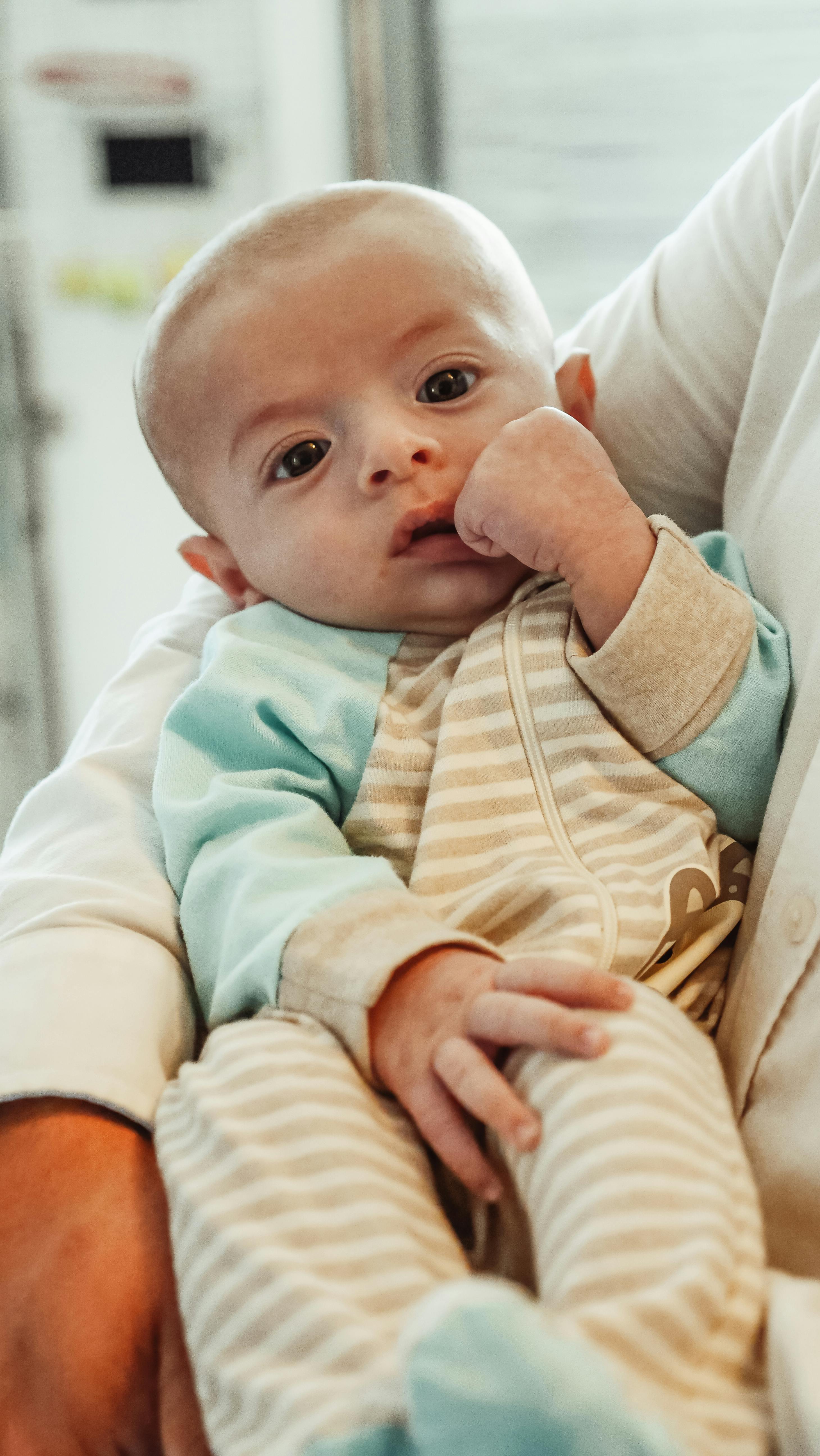 A Kid Squeezing the Face of a Baby · Free Stock Photo