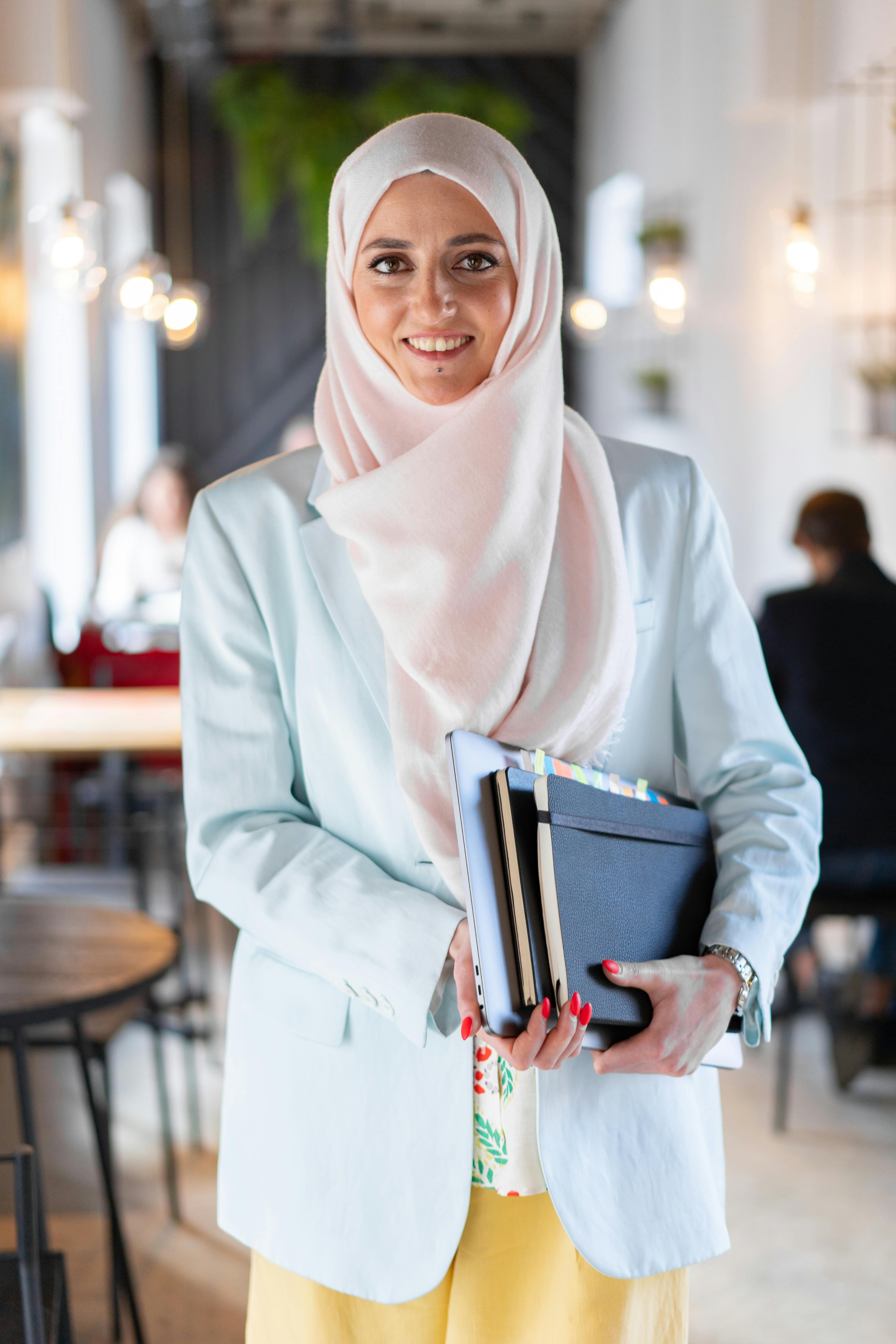 A Woman Carrying Laptop and Books · Free Stock Photo