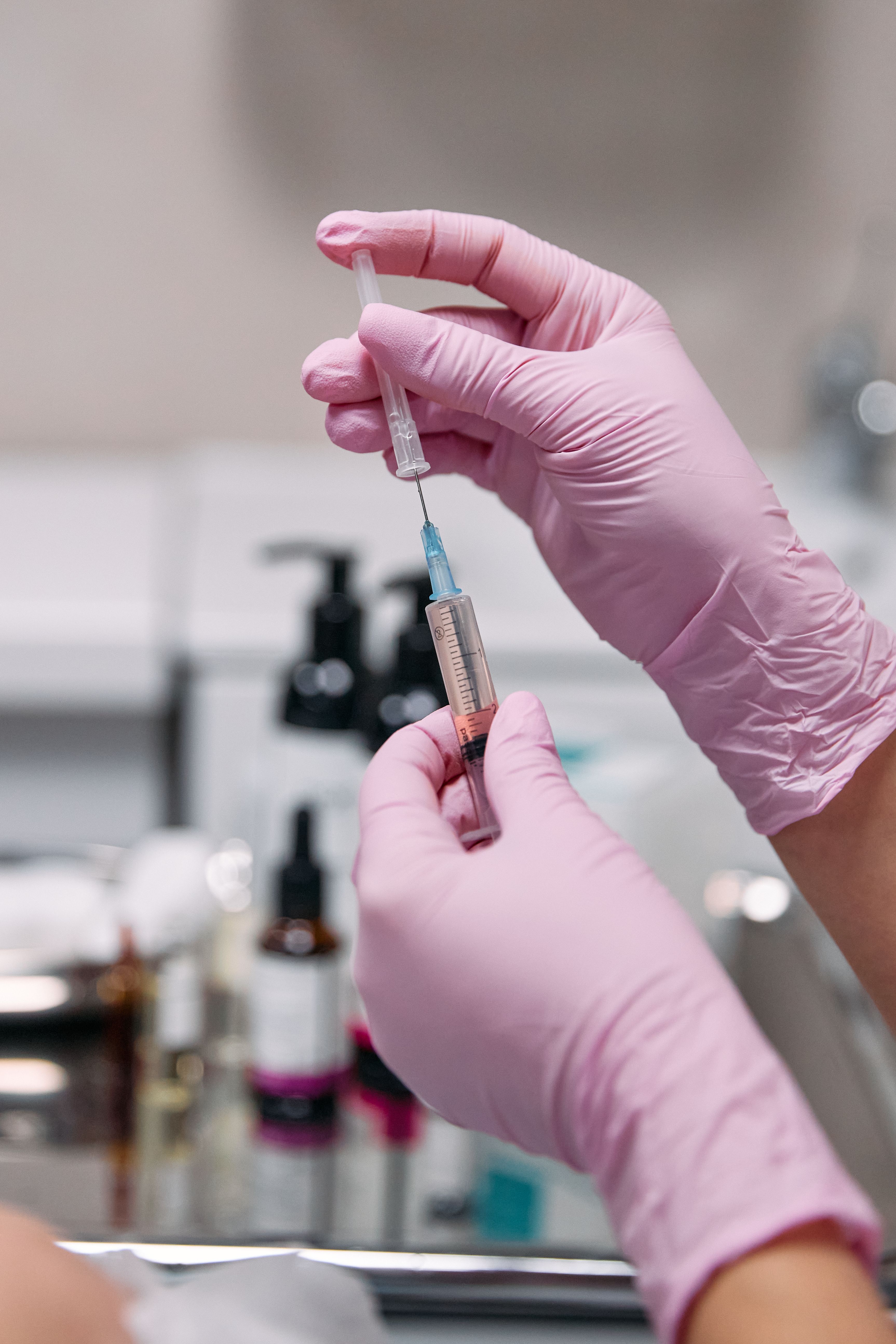 Hands Wearing Medical Gloves Injecting Syringe on Client's Face · Free ...