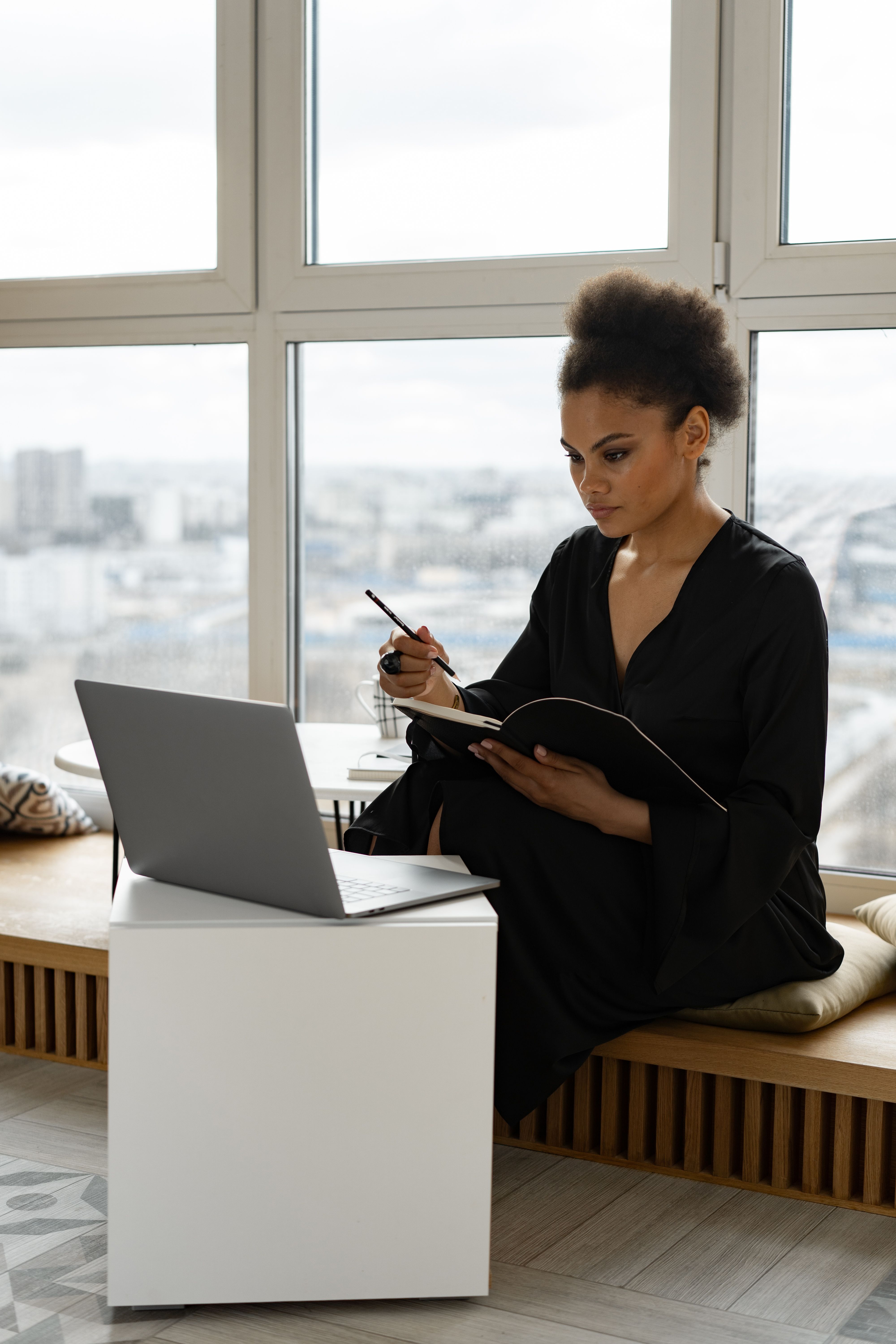 A Woman Writing in Notebook Looking the laptop · Free Stock Photo