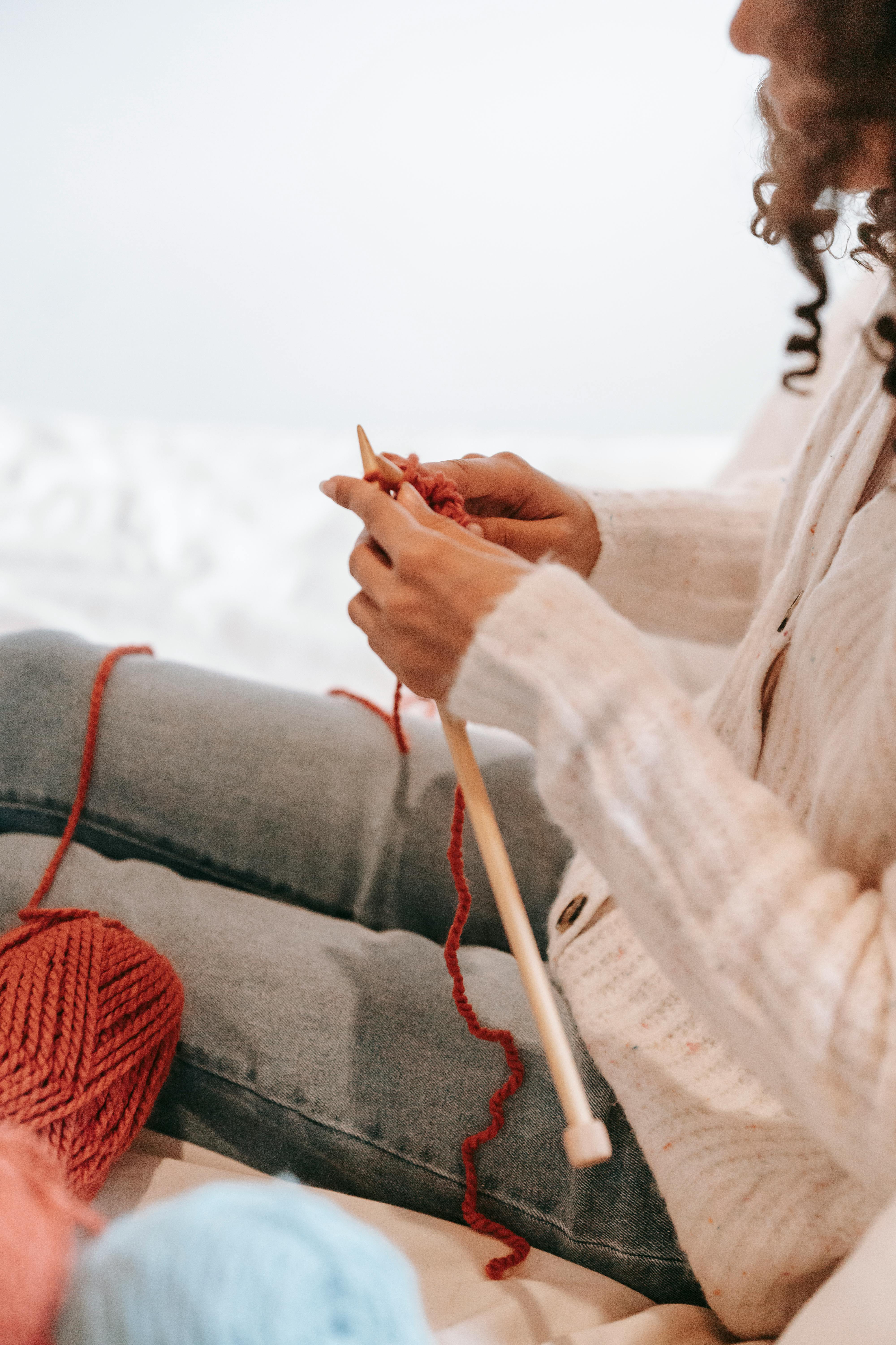 Crop black artisan knitting on bed at home · Free Stock Photo