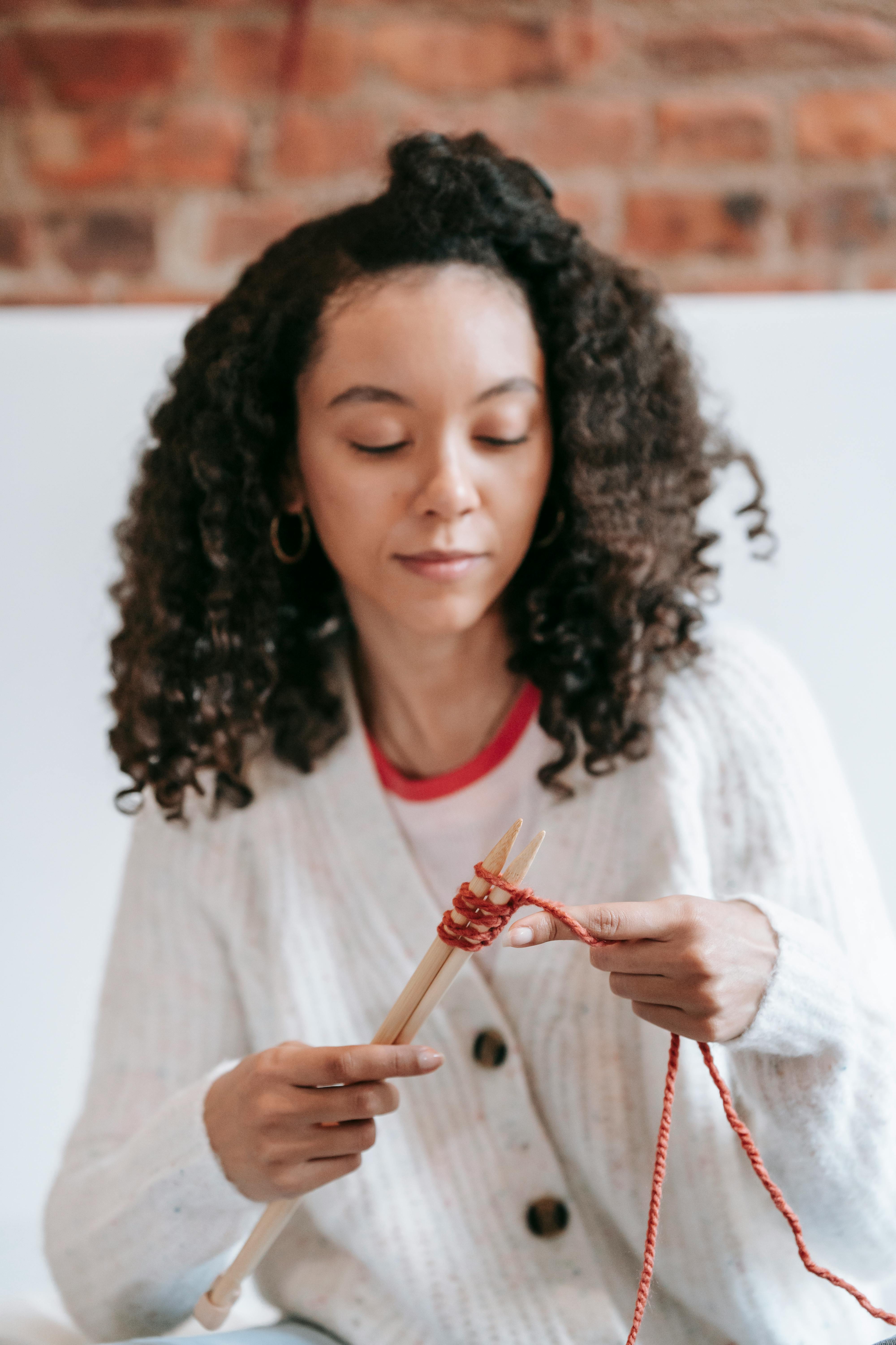 Black artisan with knitting needles and yarn at home · Free Stock Photo