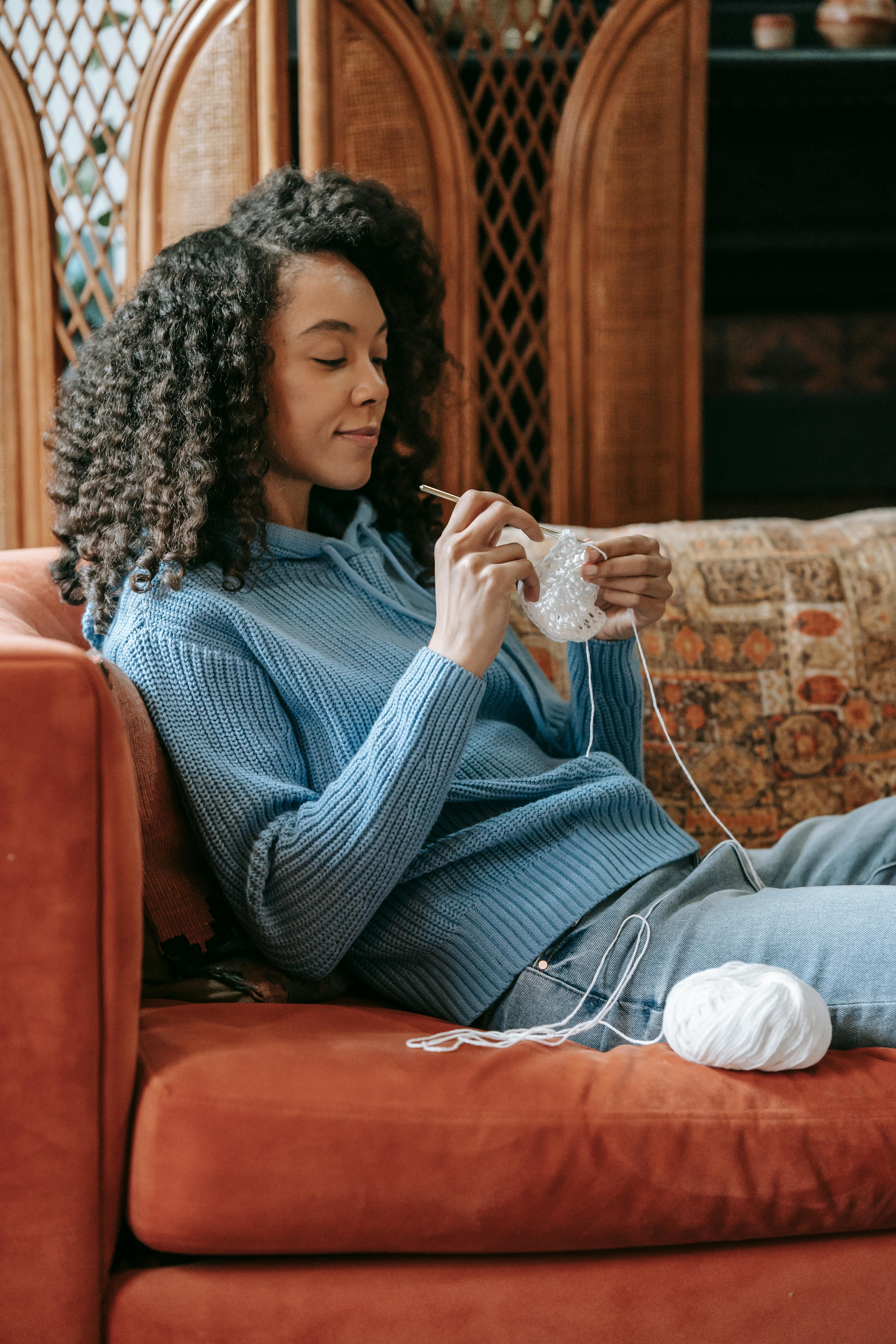 Black woman knitting on sofa · Free Stock Photo