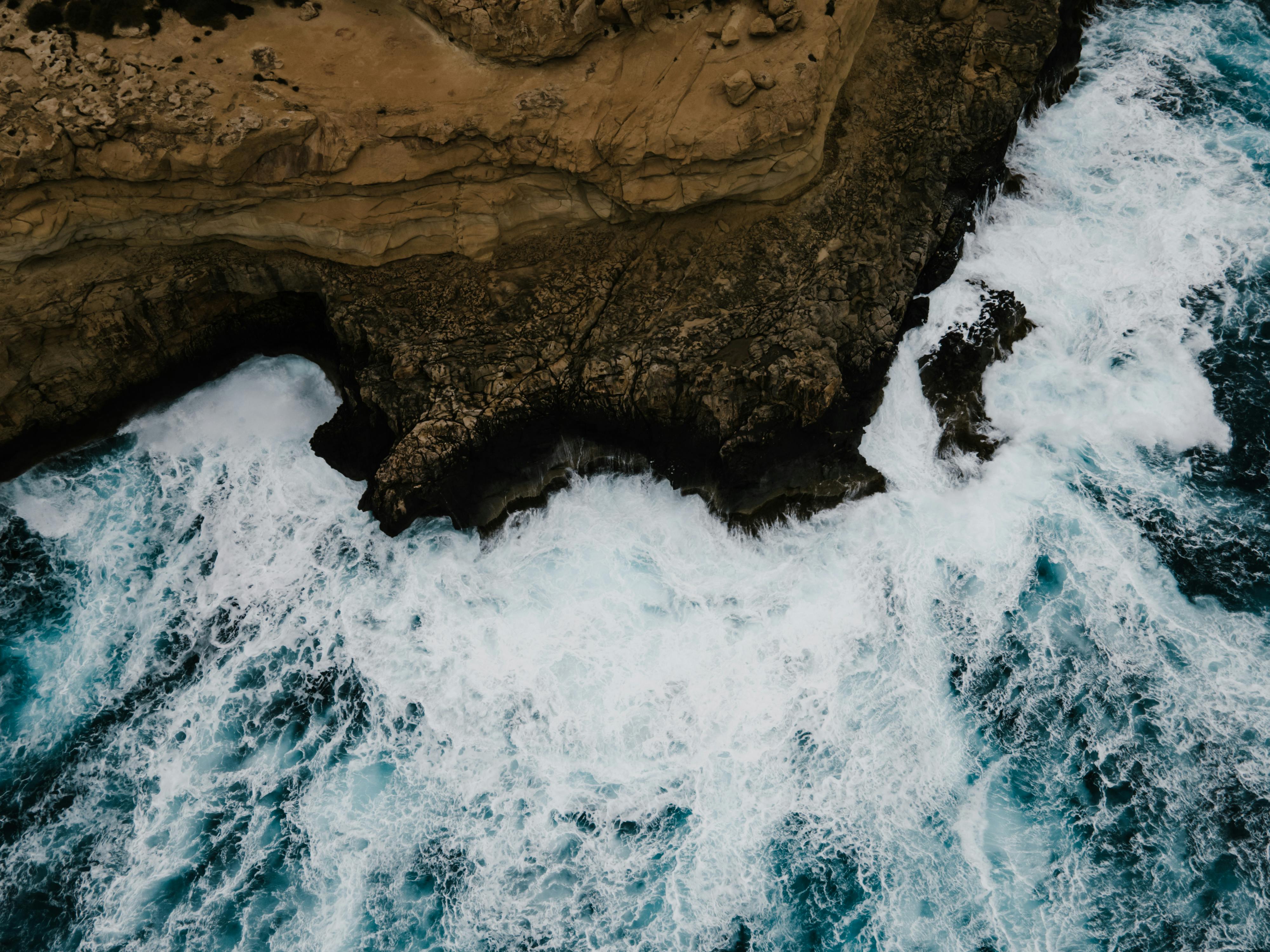 Brown Rock Formation Beside Blue Sea · Free Stock Photo
