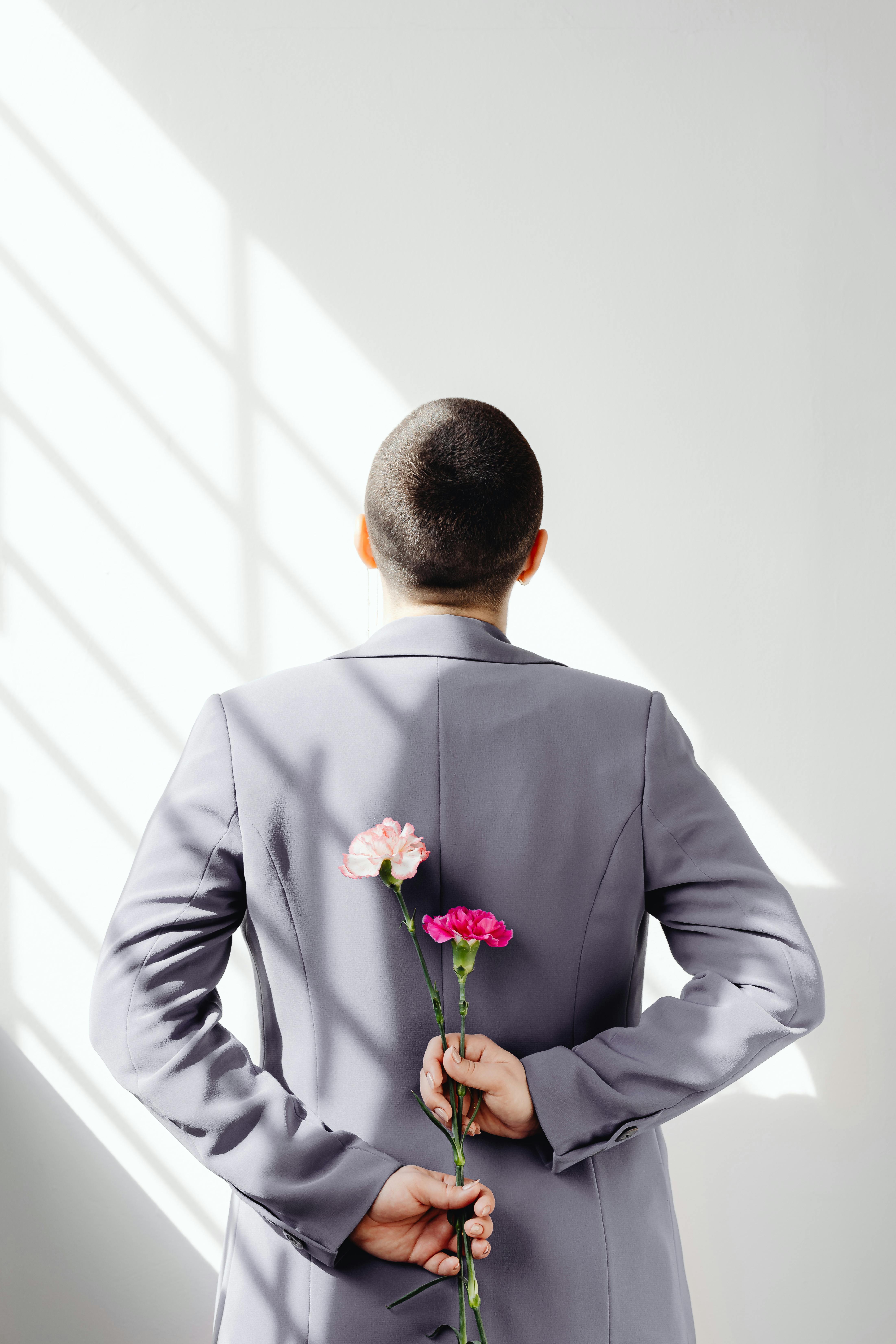 Woman Holding Flowers behind her Back · Free Stock Photo