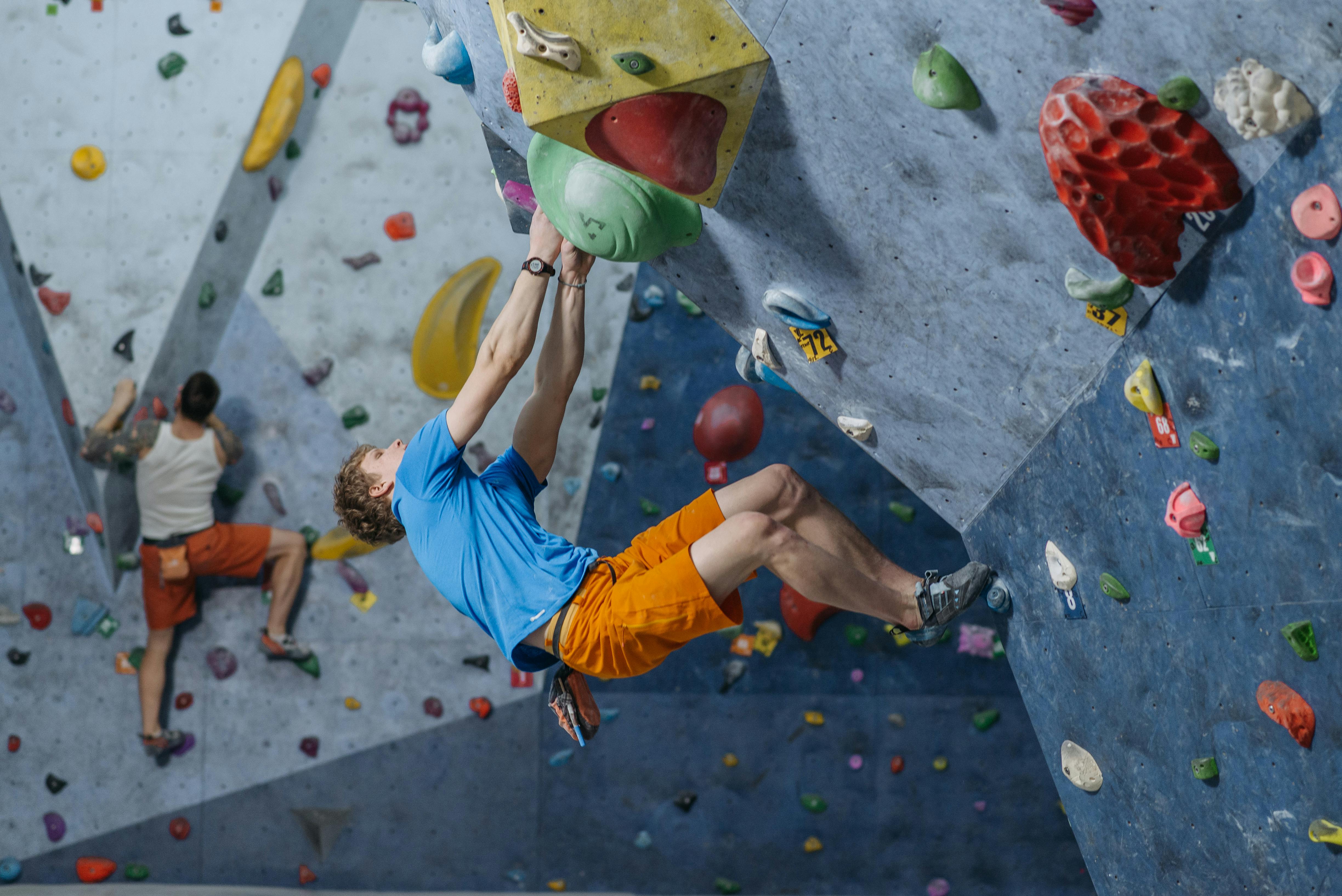 Man in Blue Shirt Climbing a Wall · Free Stock Photo