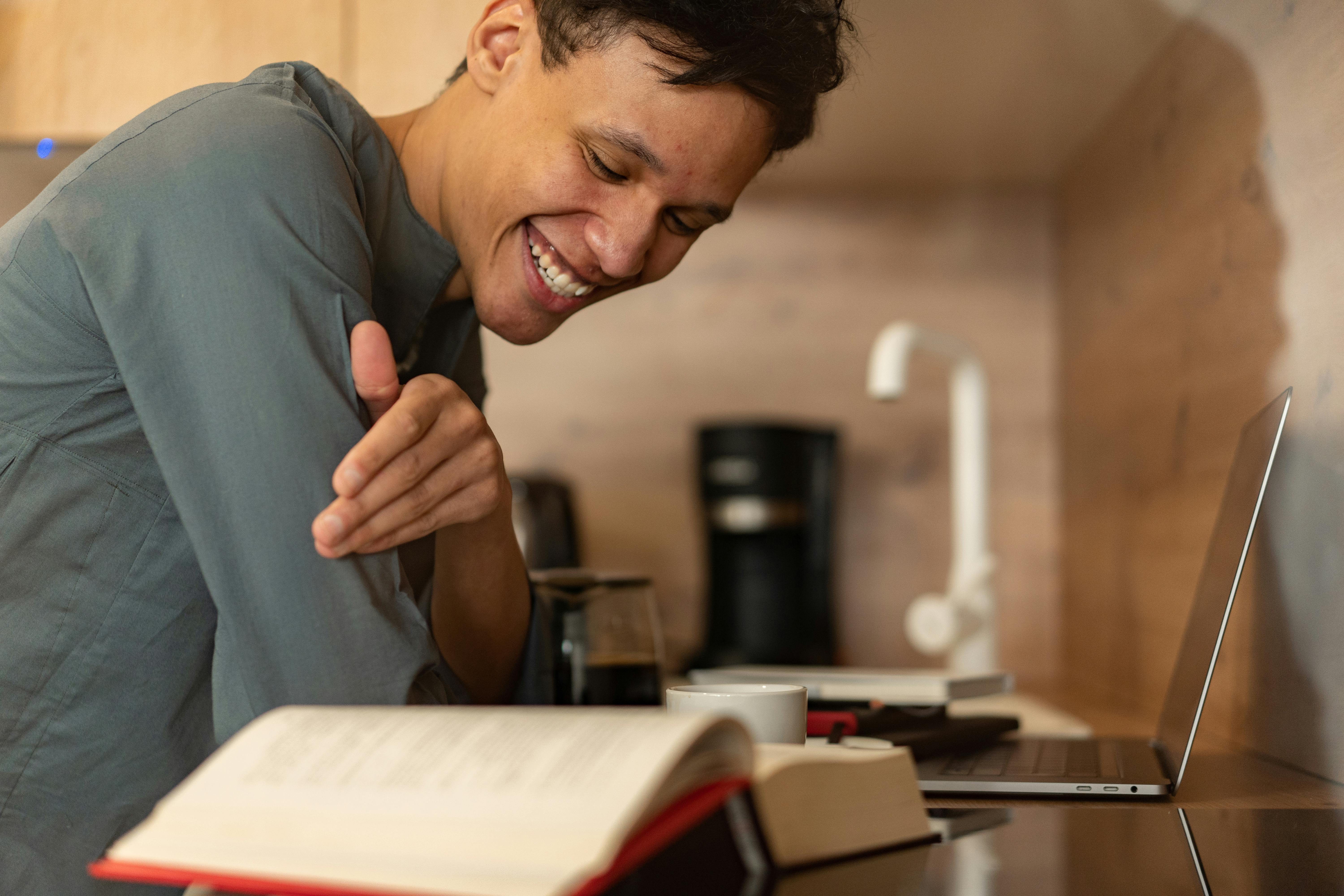 Man Laughing While Reading a Book · Free Stock Photo