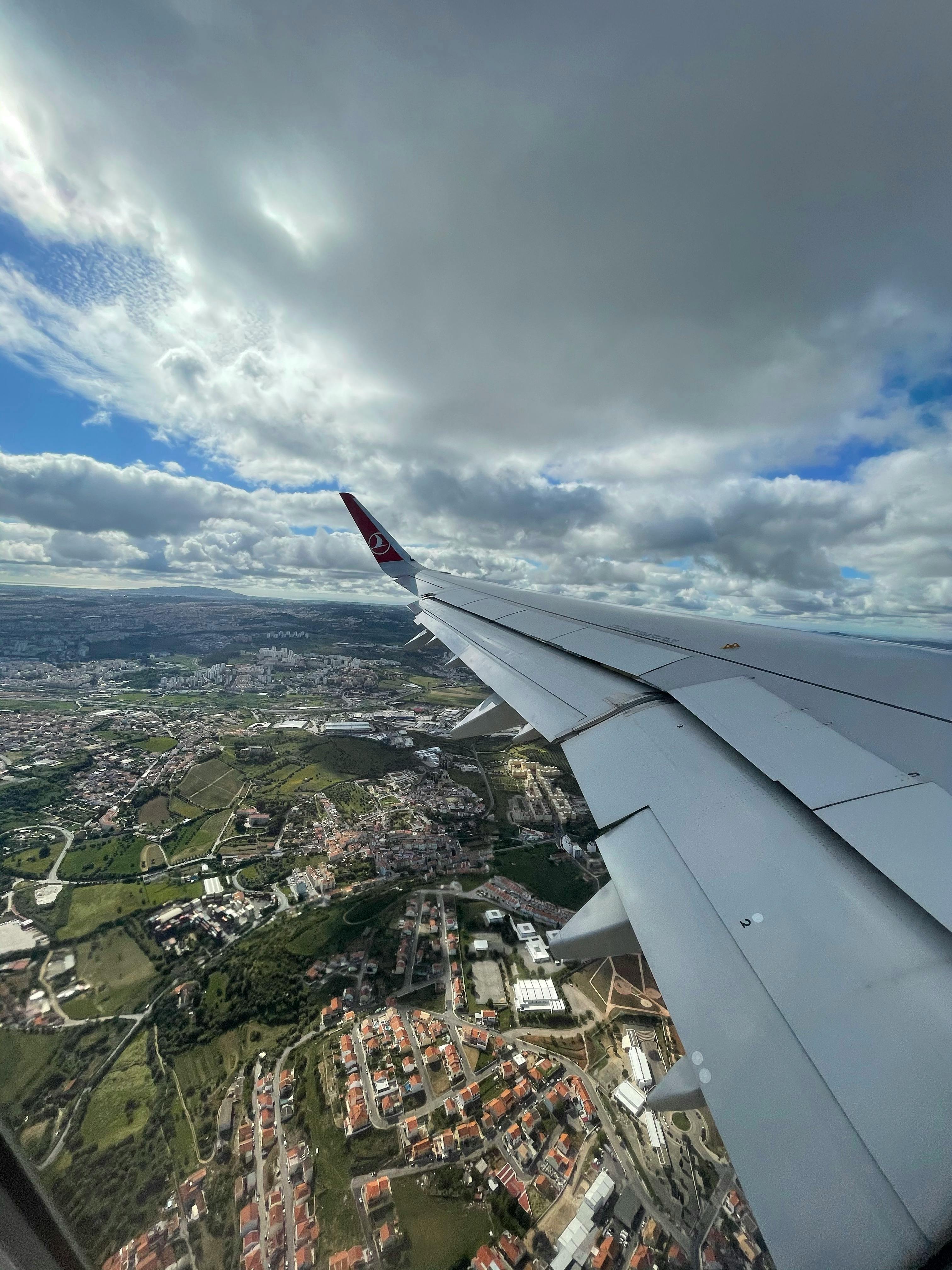 Wing of Plane Flying over City · Free Stock Photo